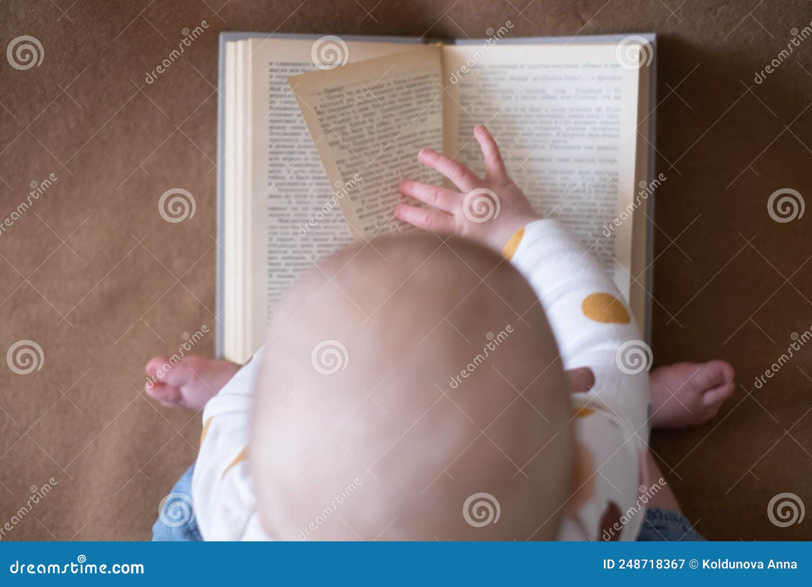 Baby Reading a Book or Looking at it in the Nursery, Learning and ...