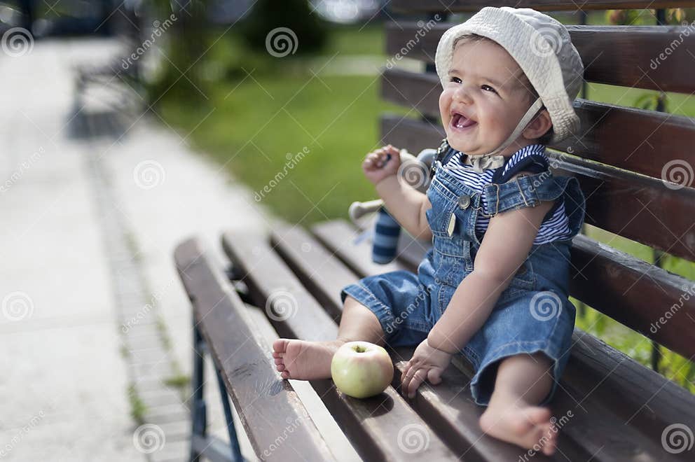 Baby sitting on the bench stock photo. Image of eating - 29399026