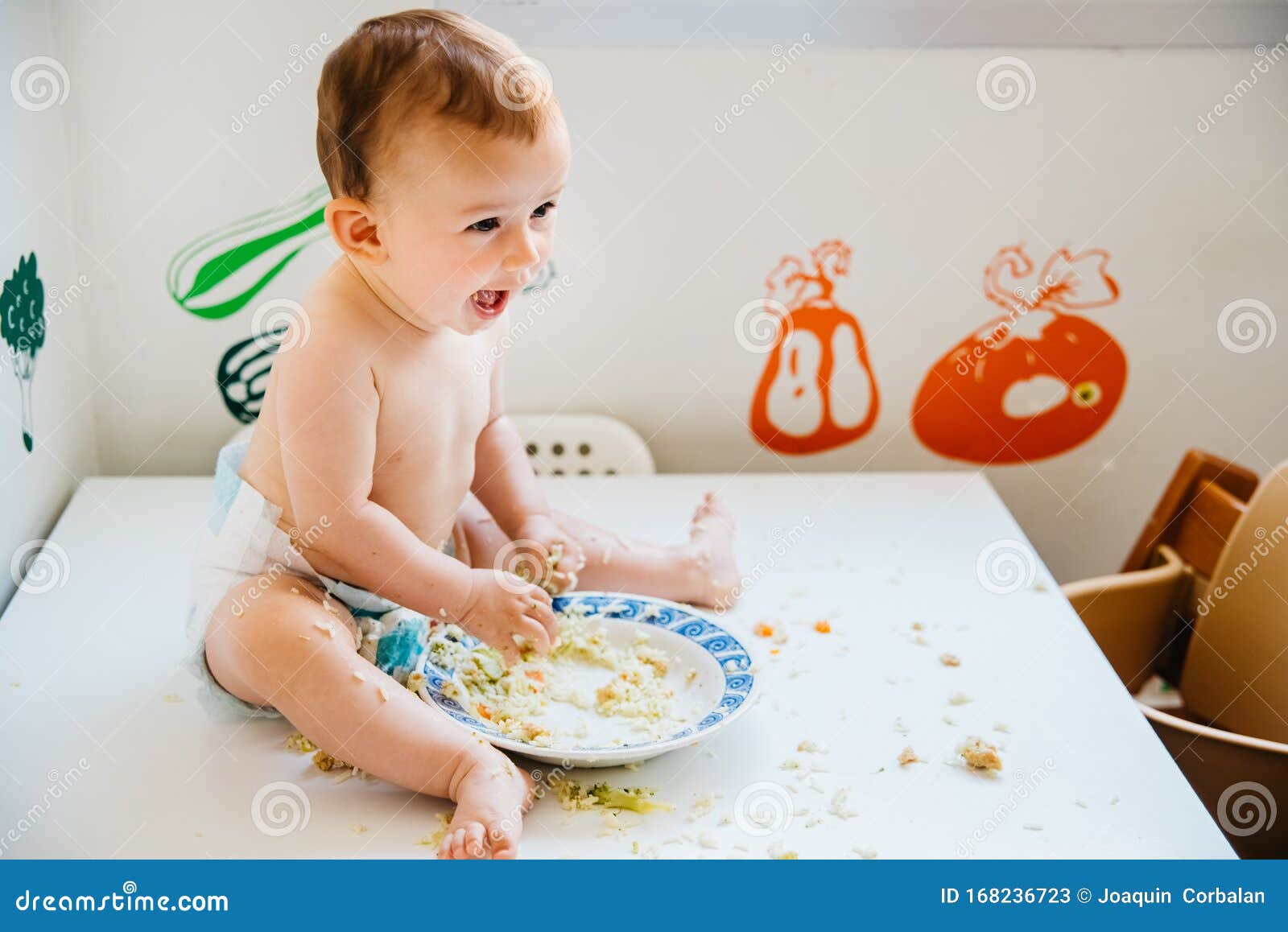 Baby Smiling while Testing His First Solid Food by Himself, Alternative ...