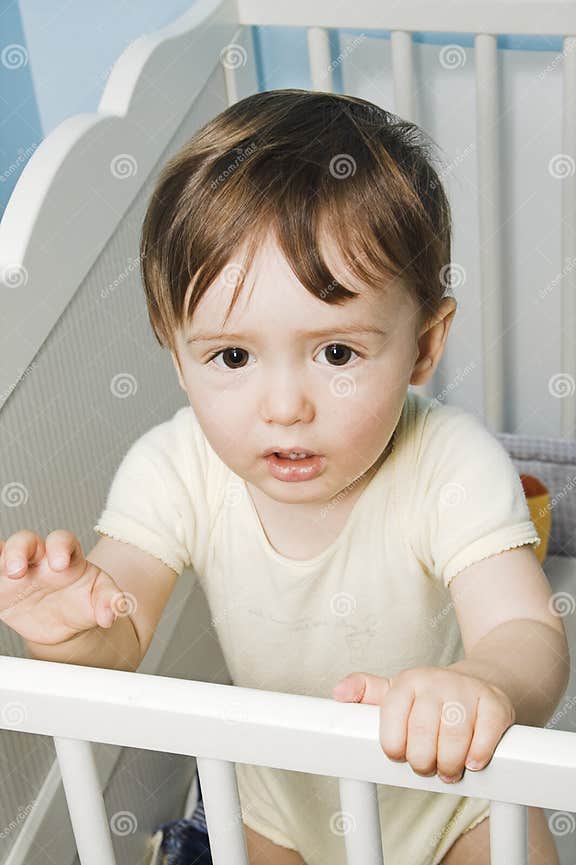 Baby standing in his crib stock image. Image of secure - 1417829