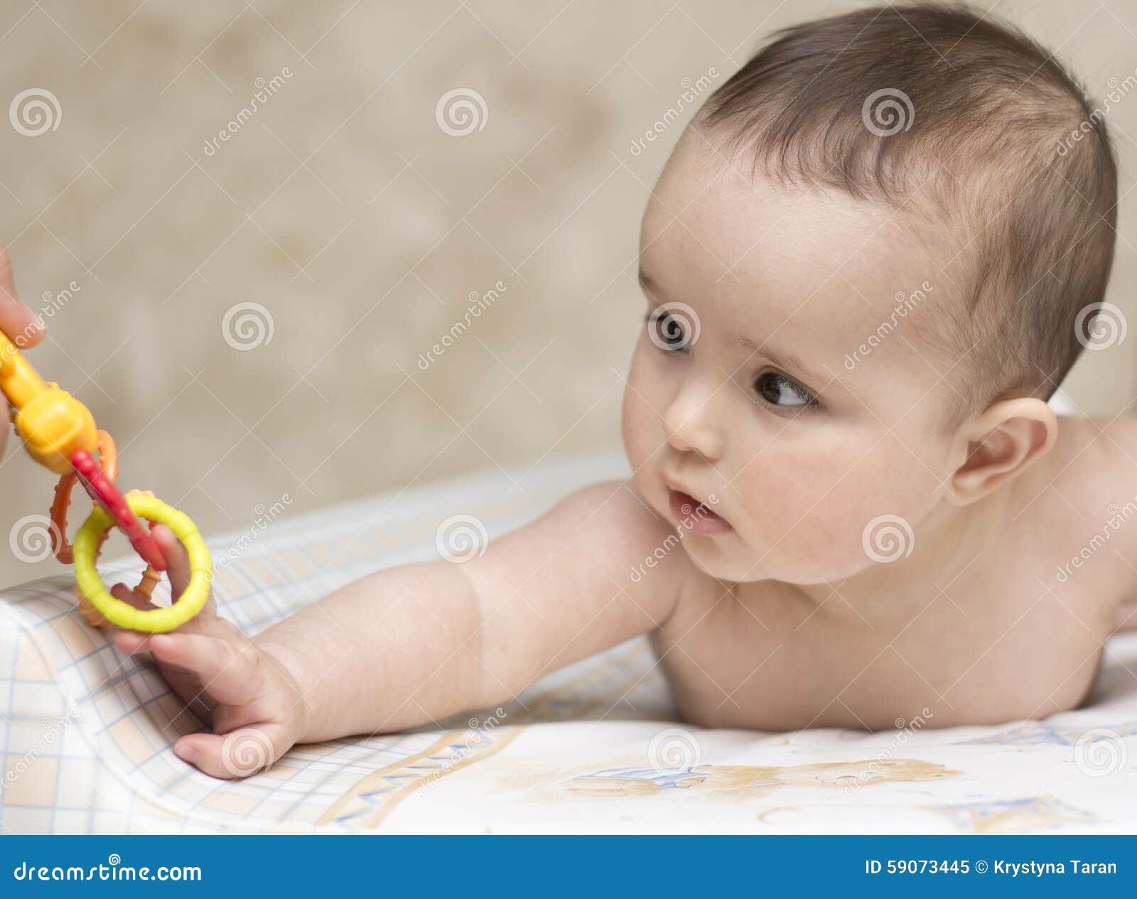 Baby Stretches Hand a Toy Rattle Stock Image - Image of background ...