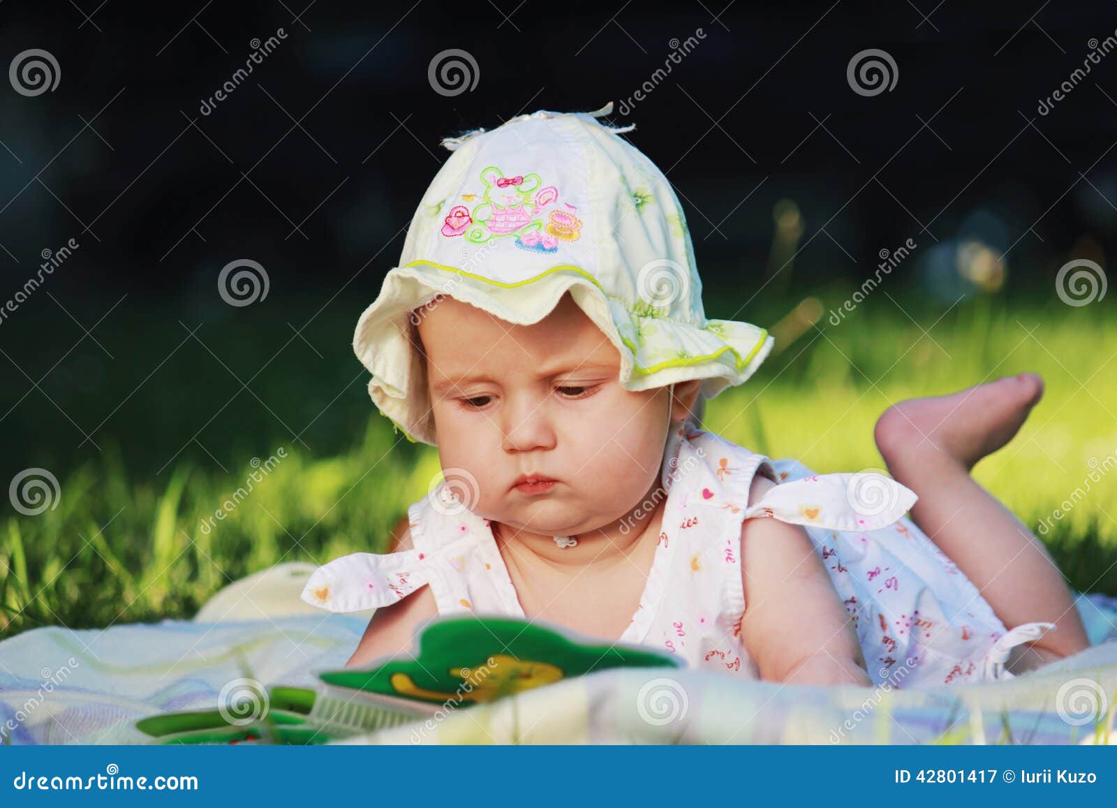 Baby is watching a book stock image. Image of park, girl - 42801417