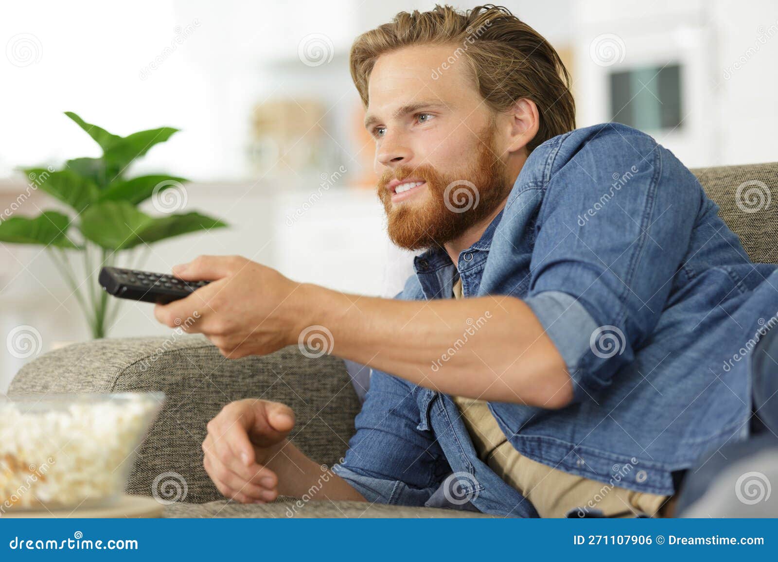 Bachelor Layed on Sofa Changing Channel with Remote Control Stock Photo ...