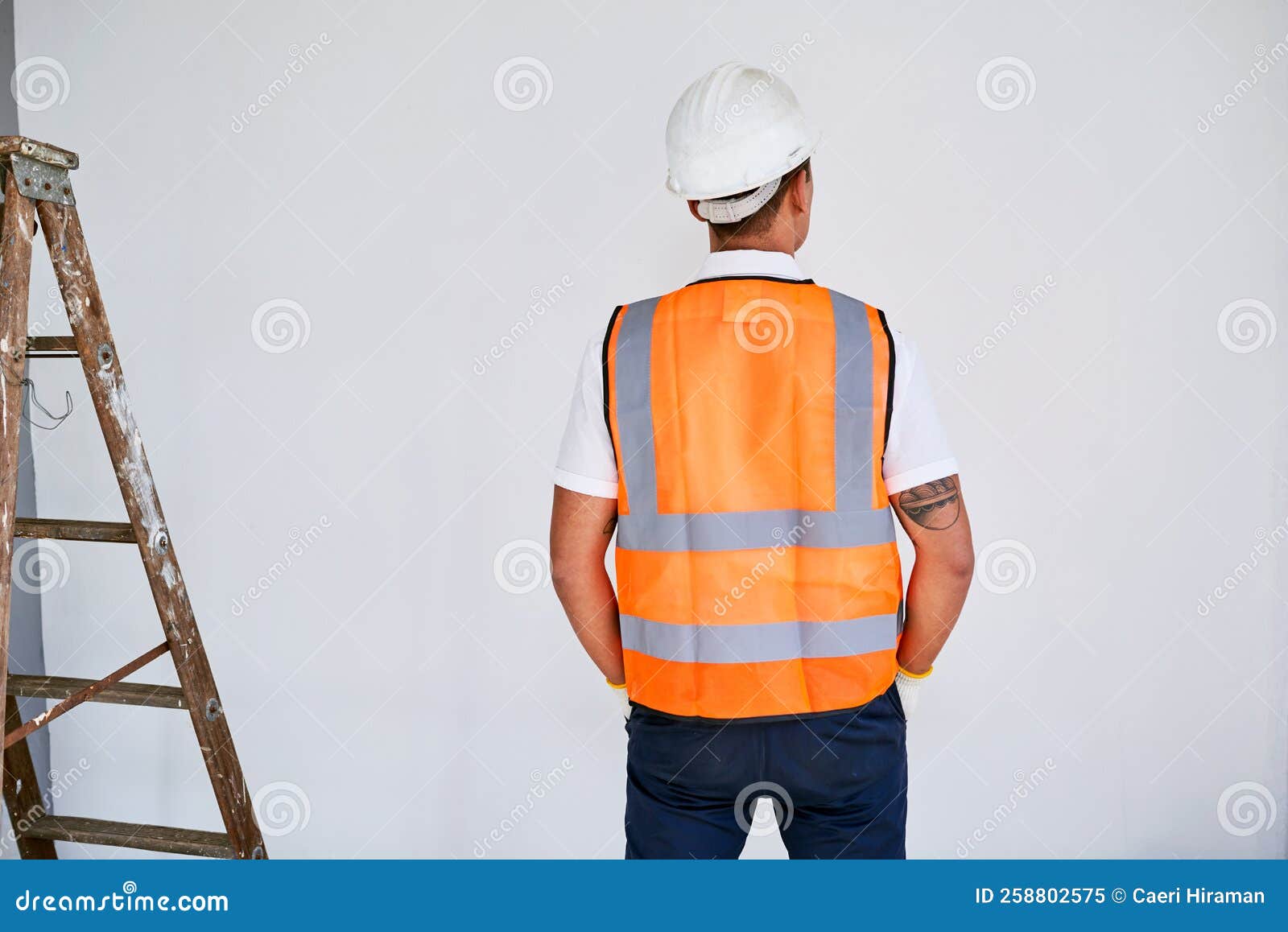 The Back of a Construction Worker As His Faces Blank Wall with Ladder ...