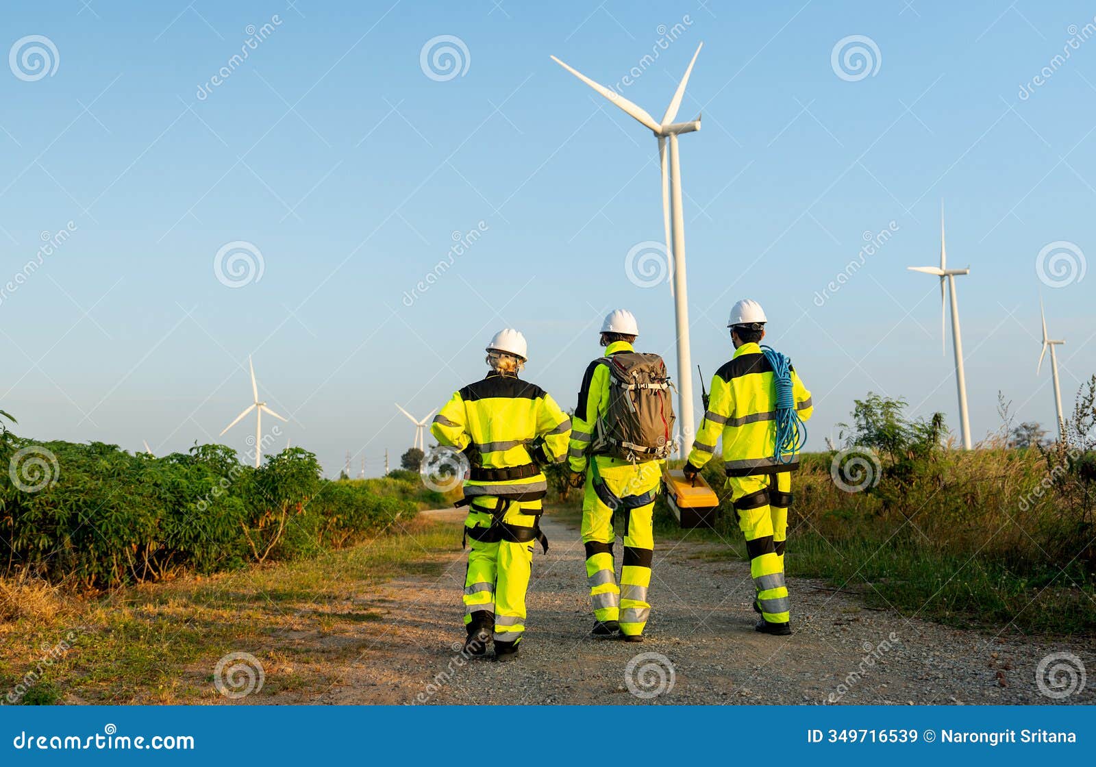 Back of Group of Wind Turbine or Windmill Workers or Technicians Carry ...