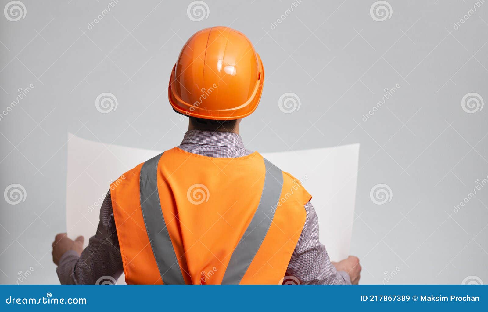 Back of Man in Uniform Looking in Opened Building Plan, Consruction ...