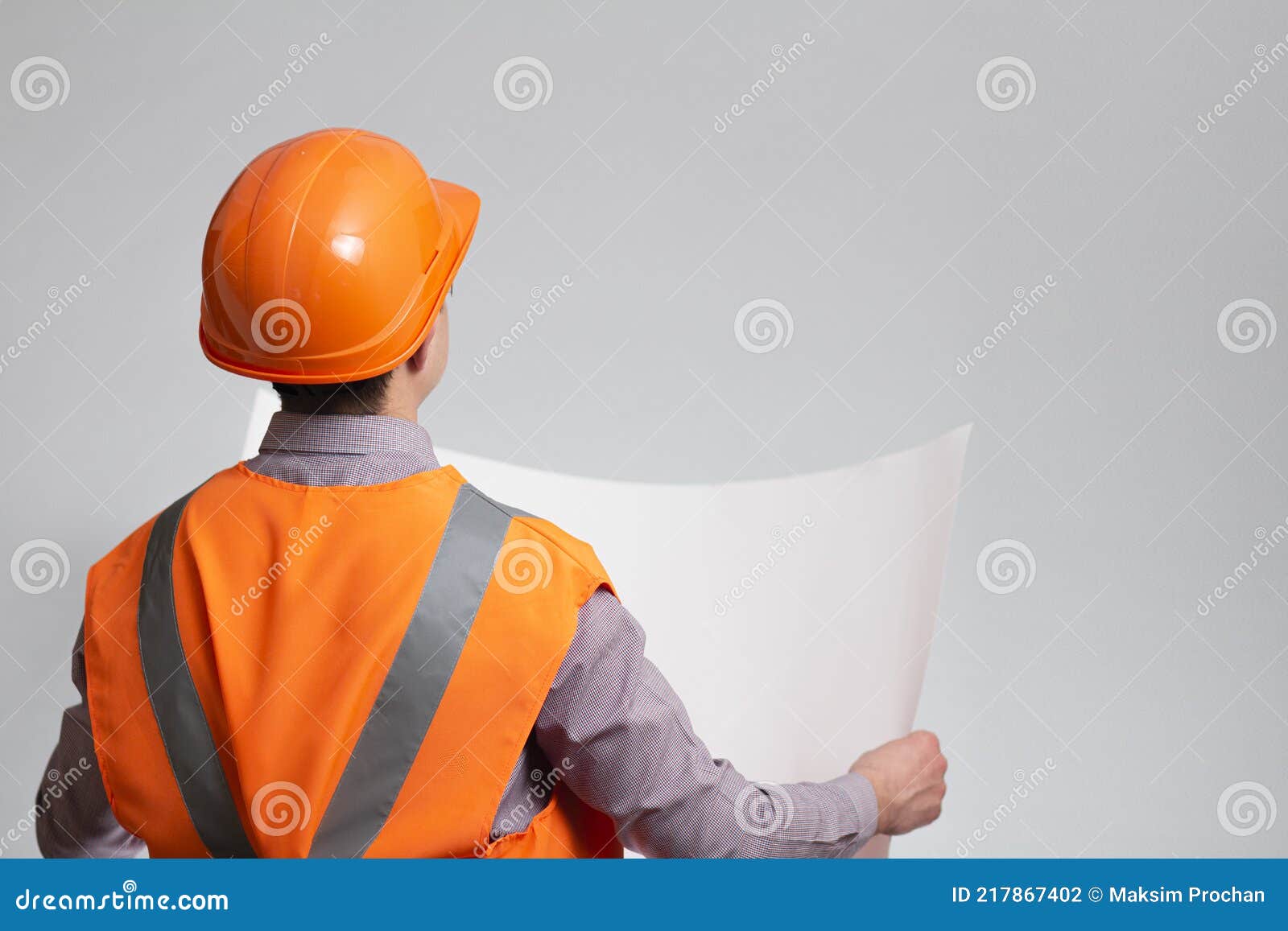 Back of Man in Uniform Looking in Opened Building Plan, Consruction ...