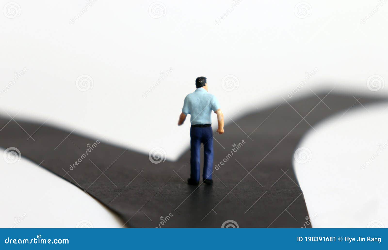 The Back of a Miniature Man Standing in Front of Two Fork Road. Stock ...
