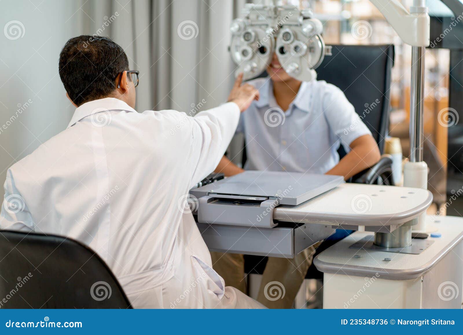Back of Optical Staff Use Machine To Measure Eyesight of Boy in Optical ...
