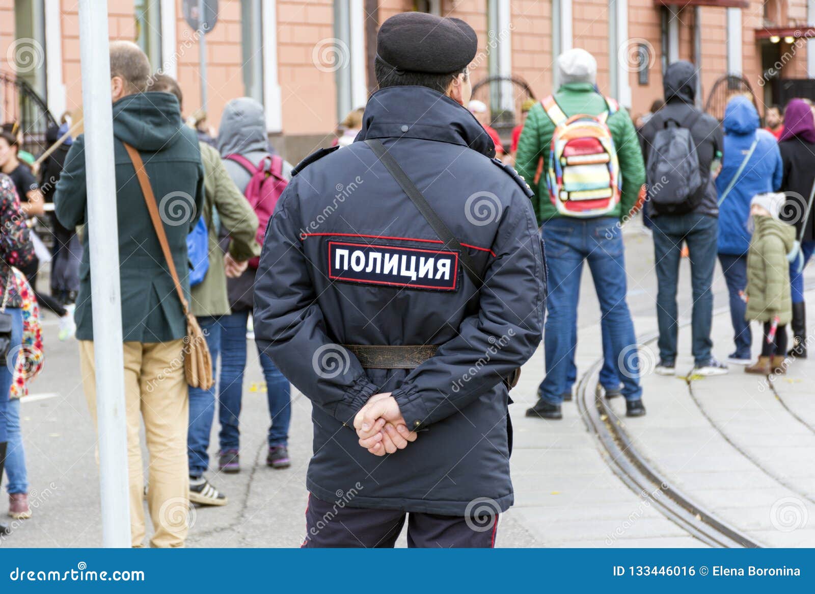 Back of a Uniformed Policeman among the People on the Street Editorial ...