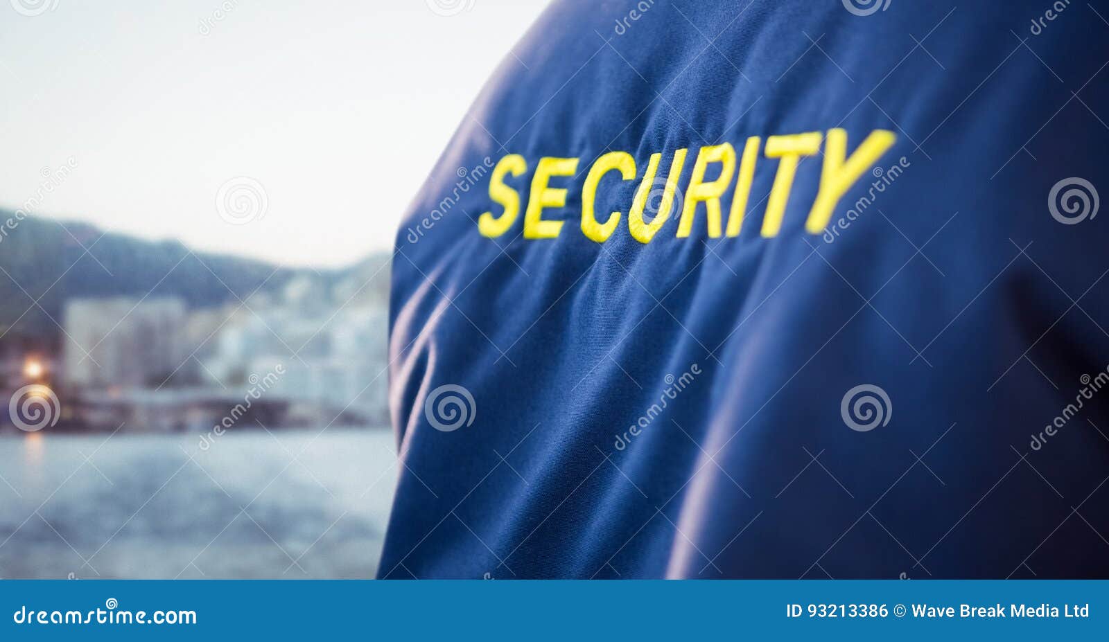 Back of Security Guard Jacket Against Blurry Skyline Stock Photo ...