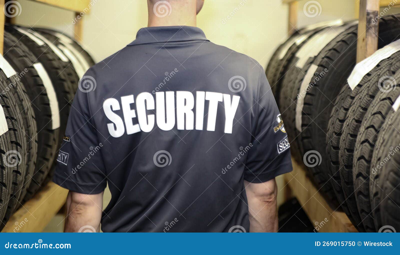 Back of a Security Guard Patrolling Inside the Warehouse of Tires ...