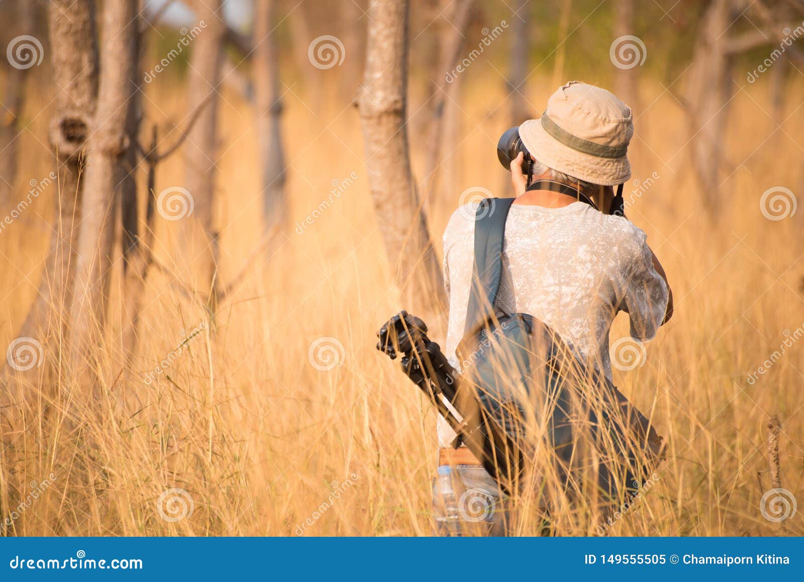 Back Side of Photographer Man in Grey Grass Field with Camera on Hand ...