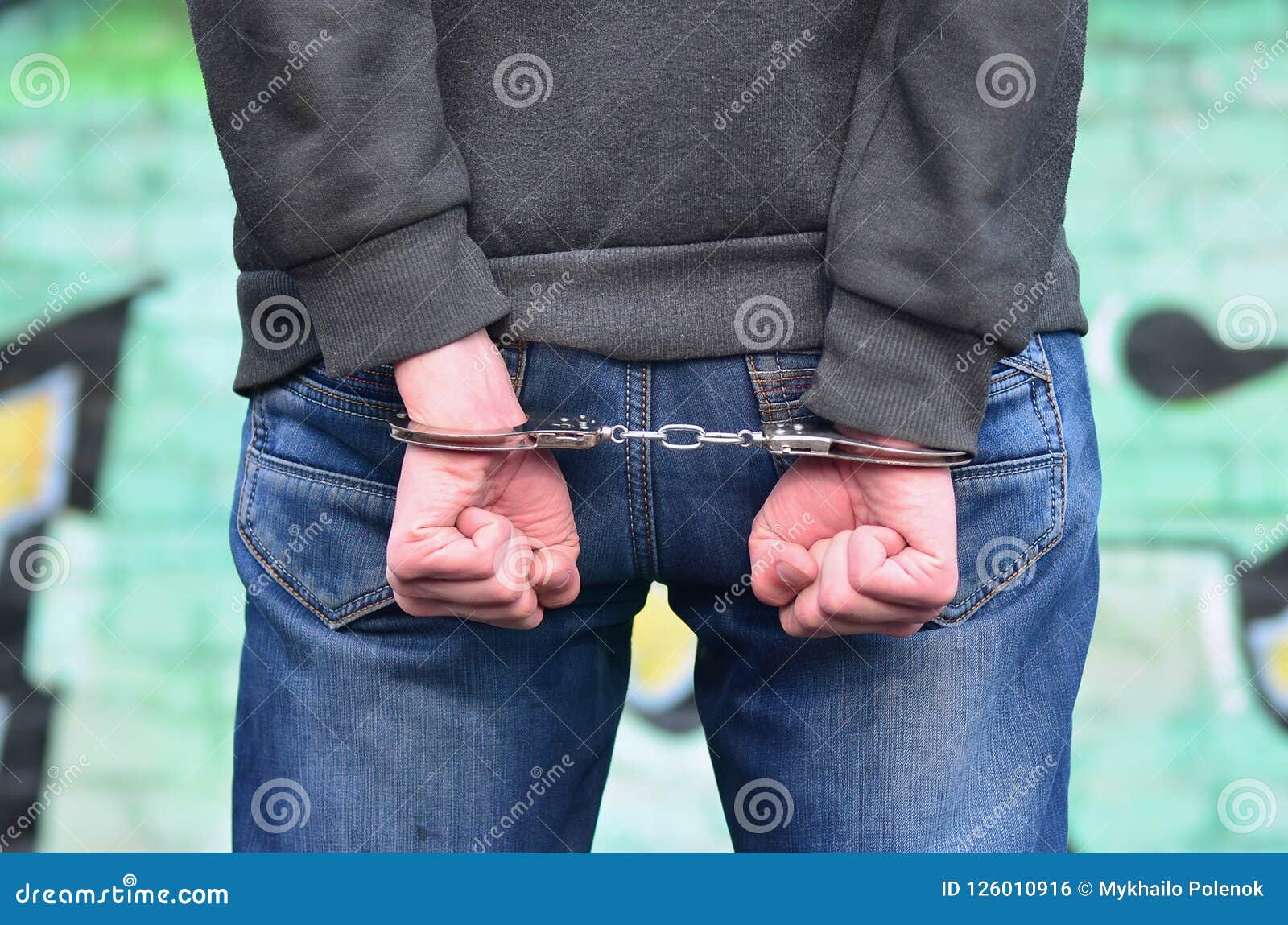 Back View of the Arrested Bandit from the Ghetto Against the Graffiti ...