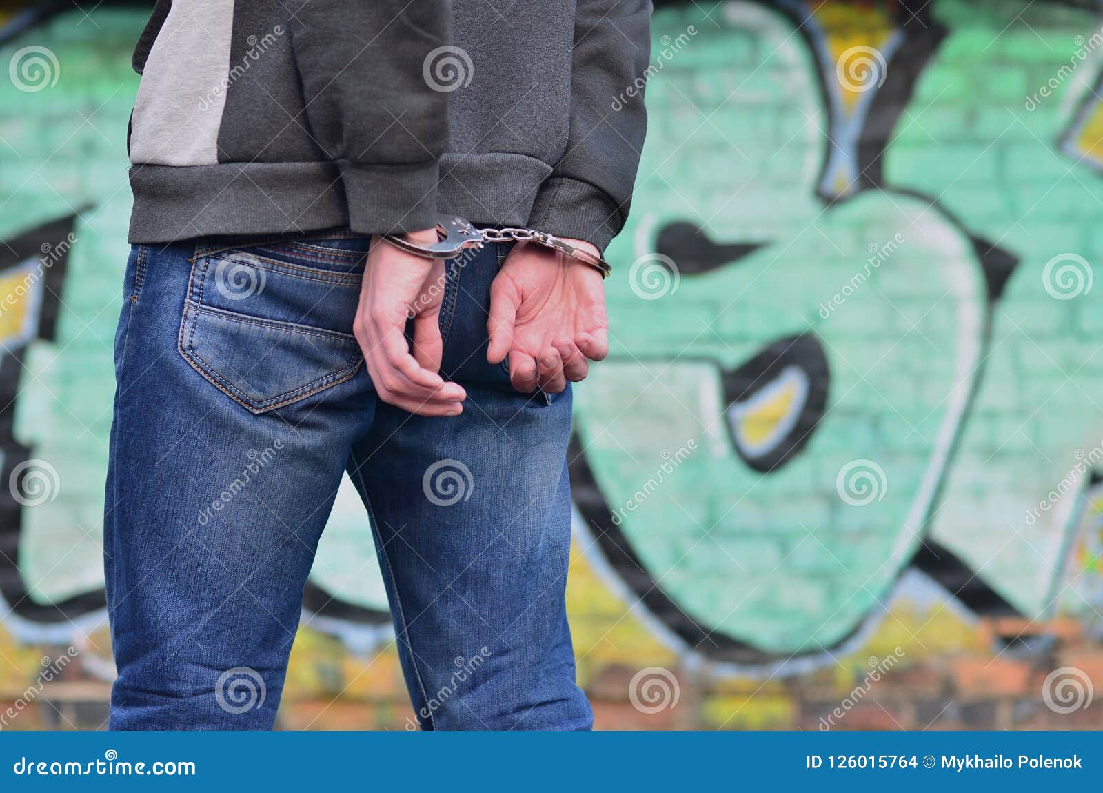 Back View of the Arrested Bandit from the Ghetto Against the Graffiti ...