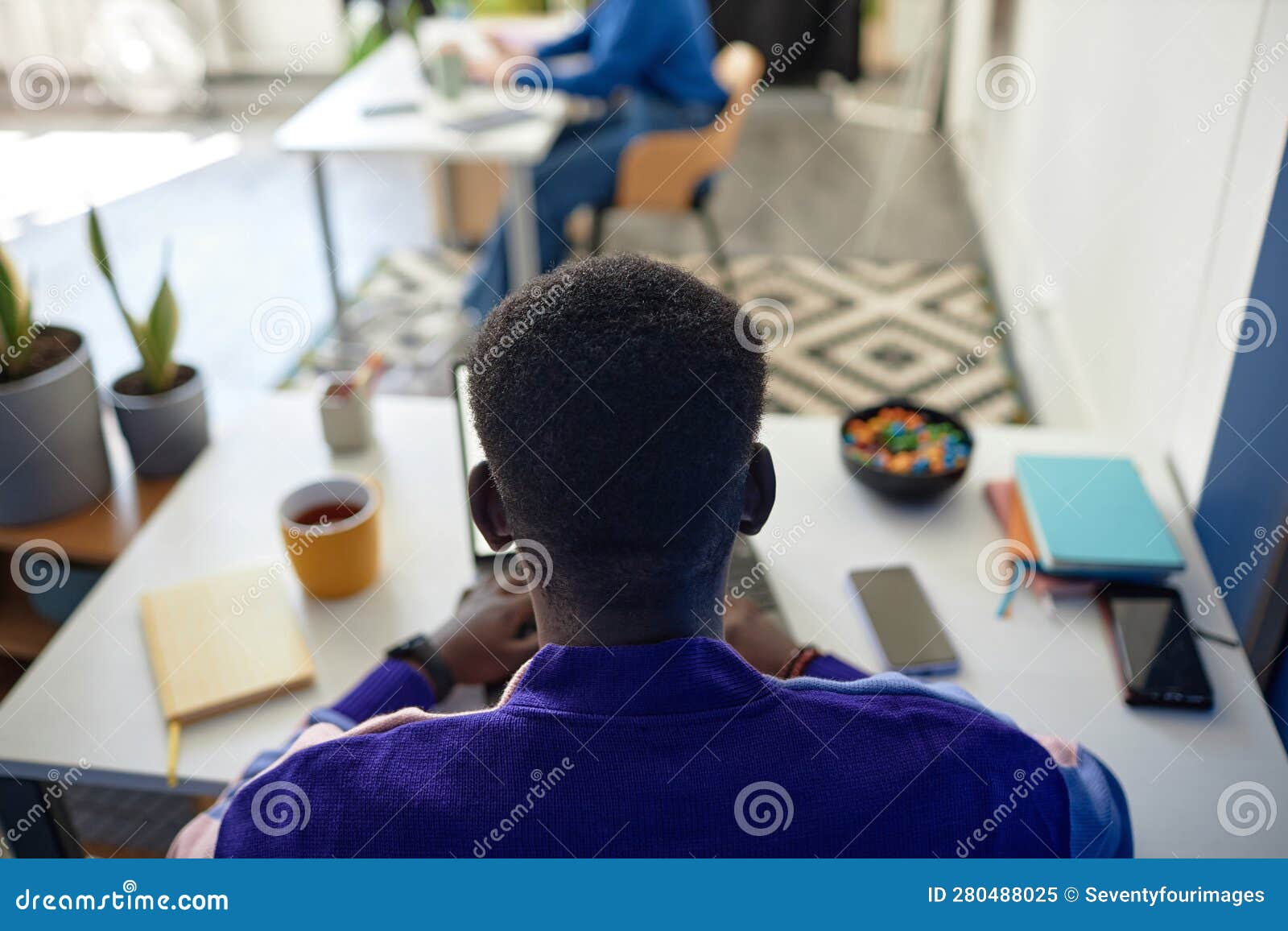 Back View at Black Man Working at Desk in Fun Non Conventional Office ...