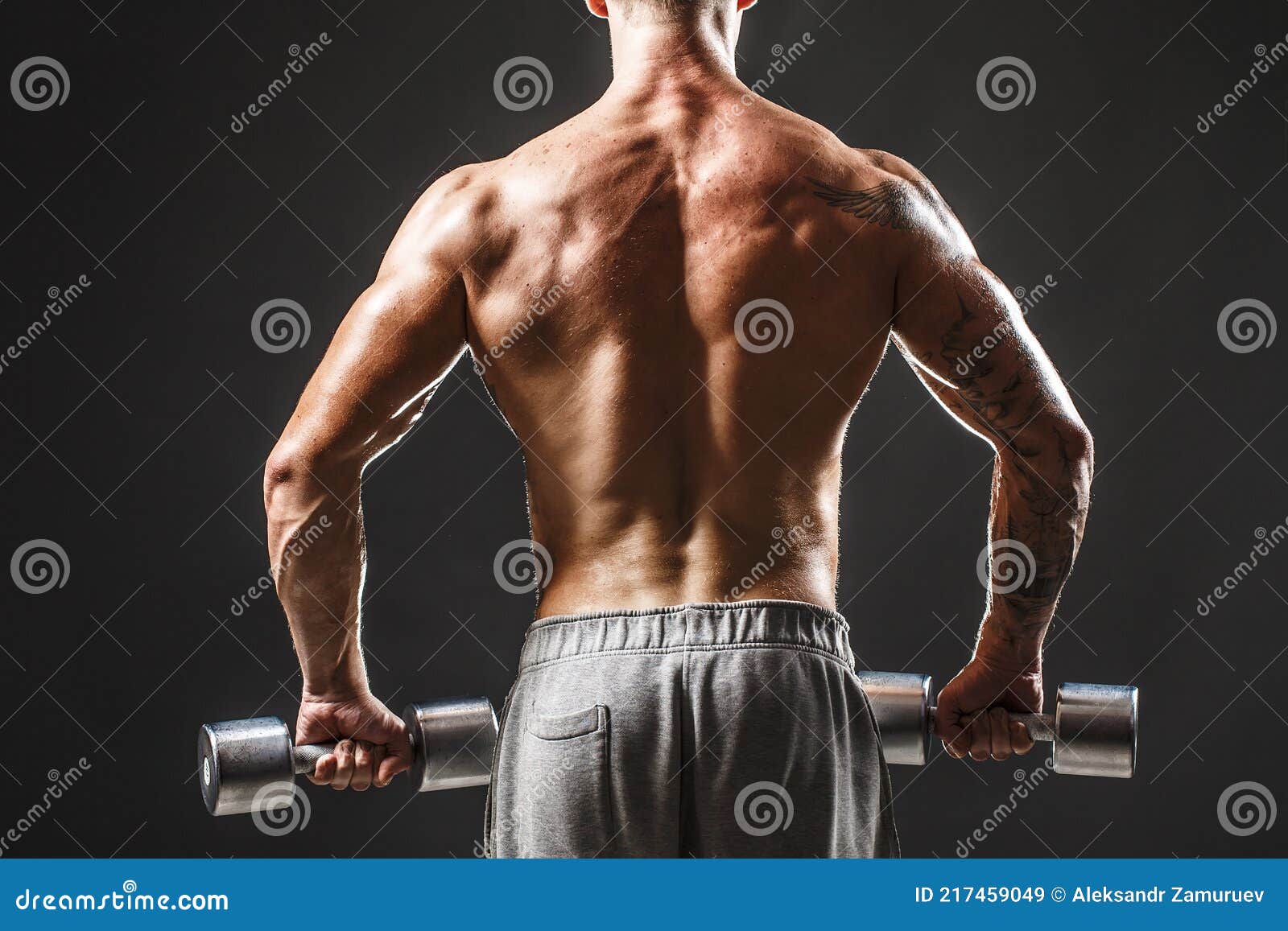 Back View of Bodybuilder Training with Dumbbell on Black Stock Image ...