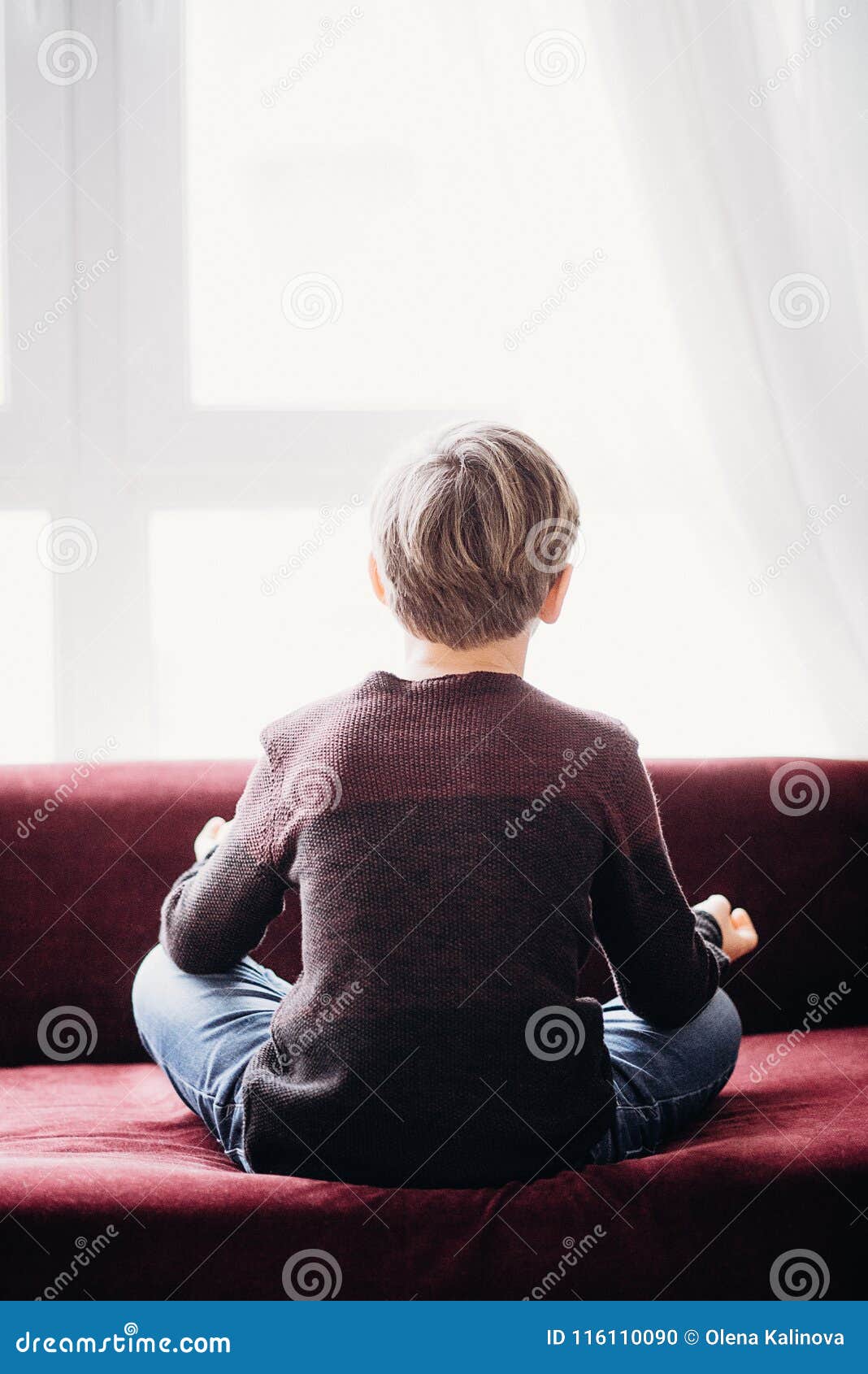 Back View of a Boy Sitting on a Sofa in a Lotus Pose Stock Photo ...