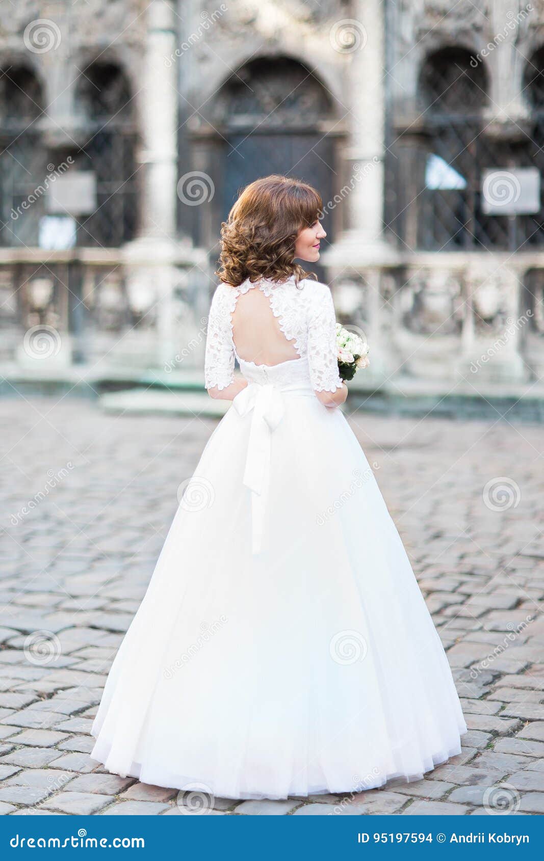 The Back View of the Bride with the Wedding Bouquet in the Street ...