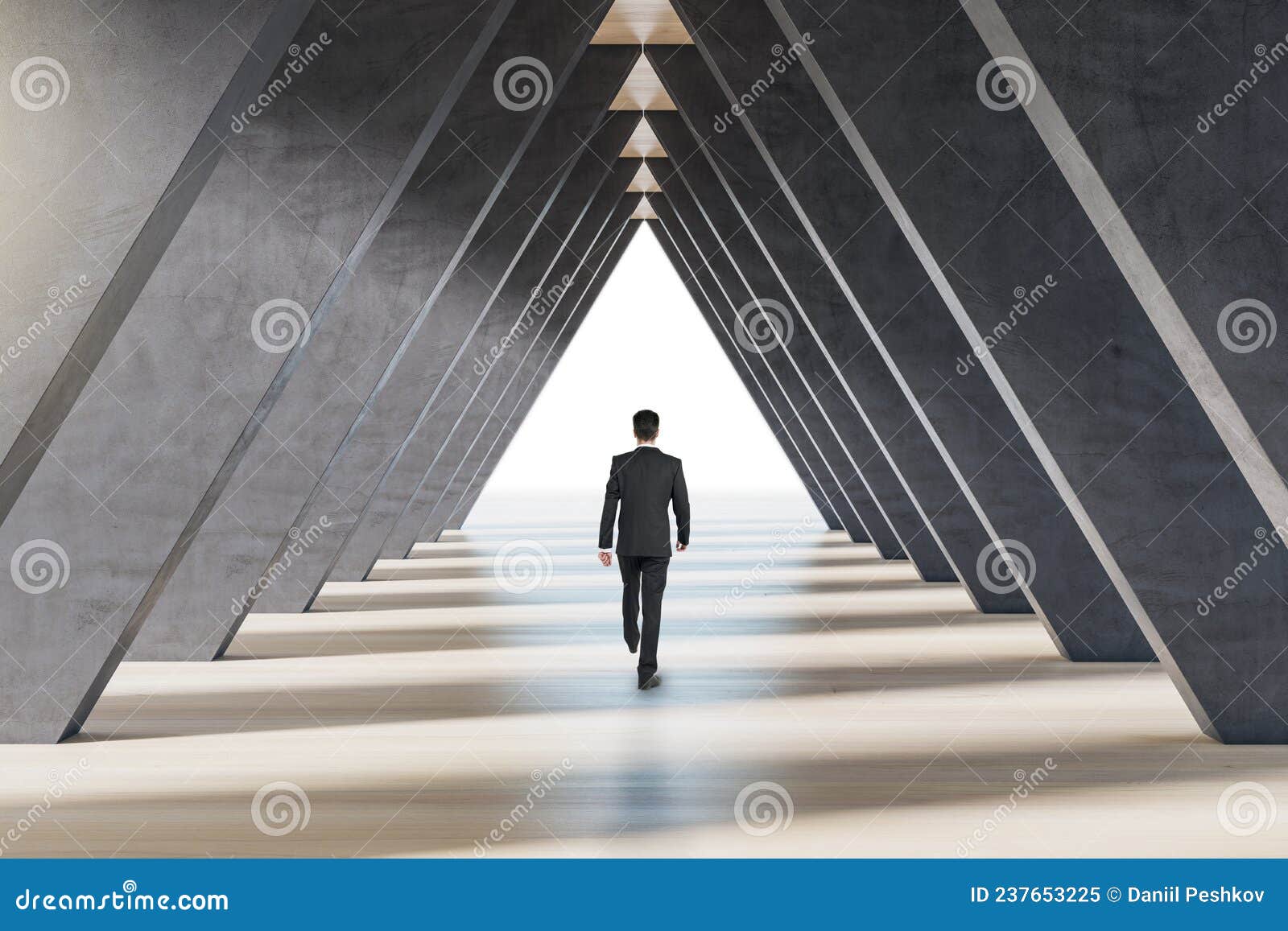 Back View of Businessman Walking in Abstract Concrete Triangle Corridor ...