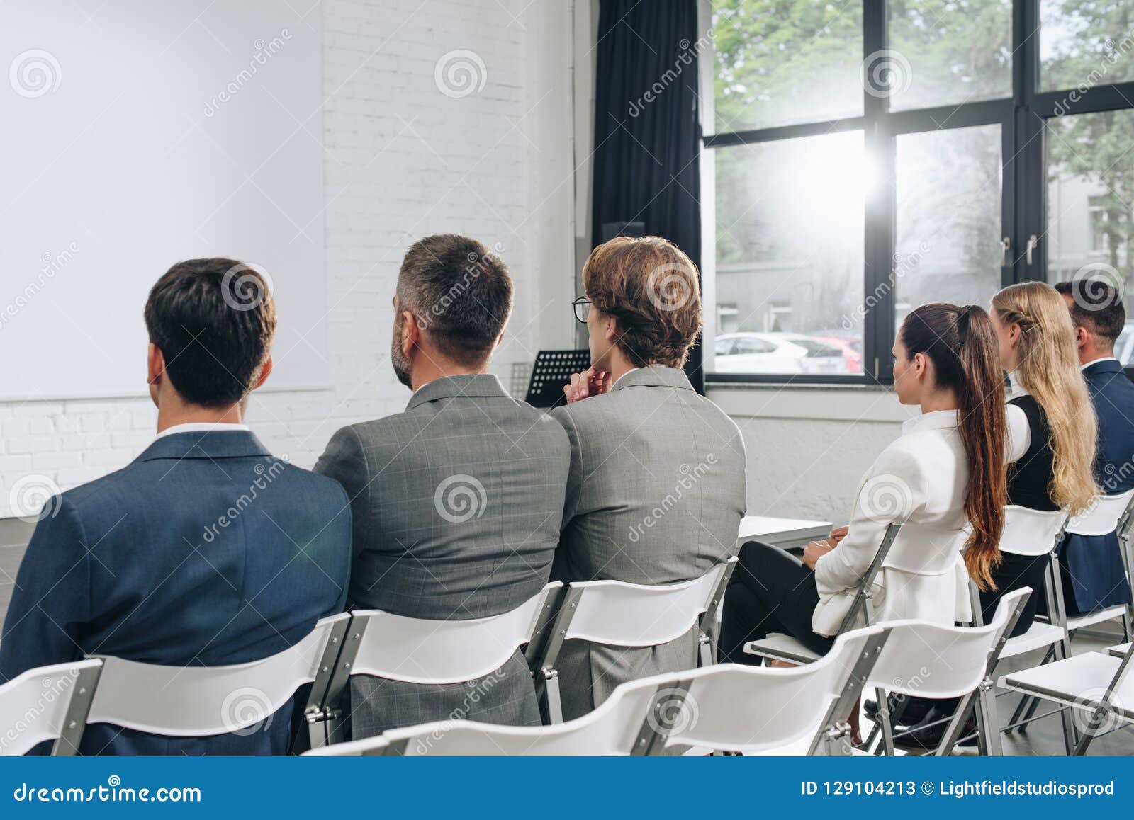 Back View of Businesspeople Sitting on Chairs during Training Stock ...