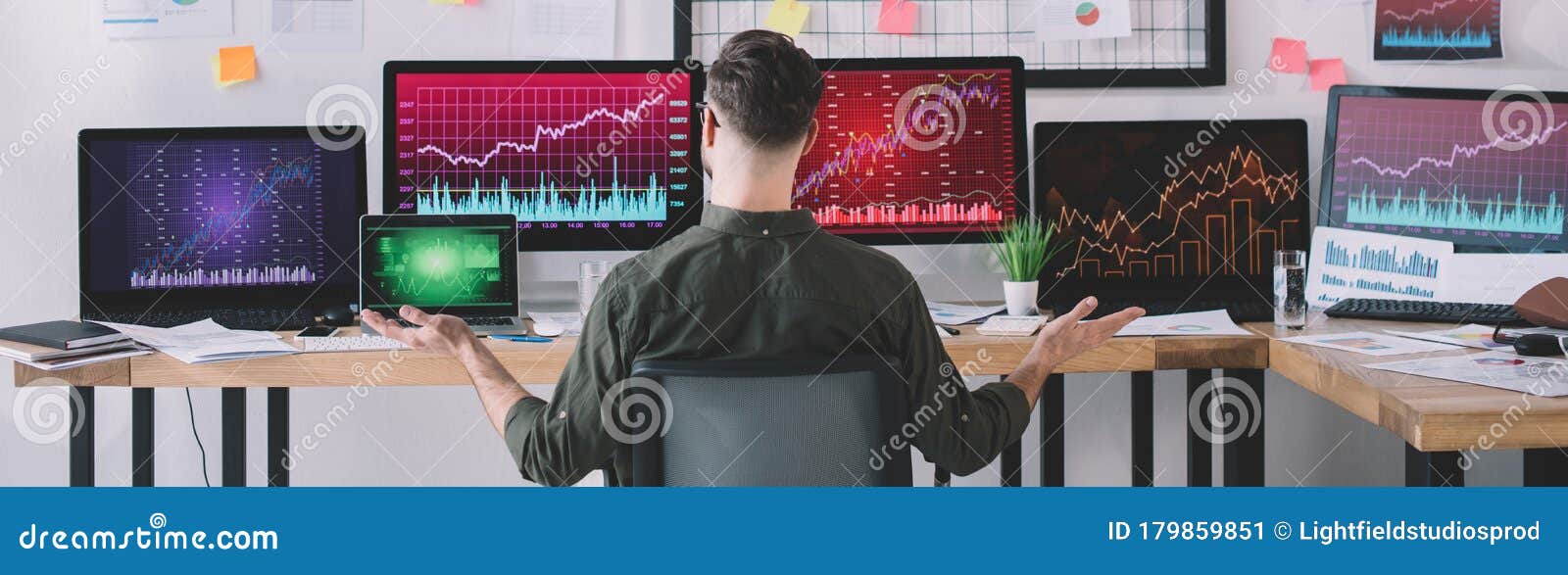 Back View of Data Analysts Sitting at Table with Computers and Charts ...