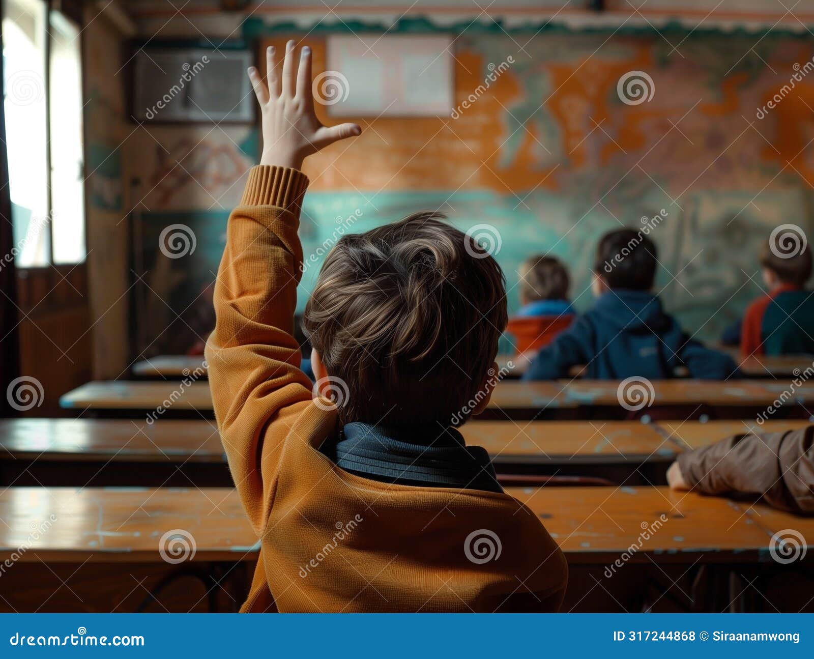 Back View of Elementary Student Raising His Hand To Answer a Question ...
