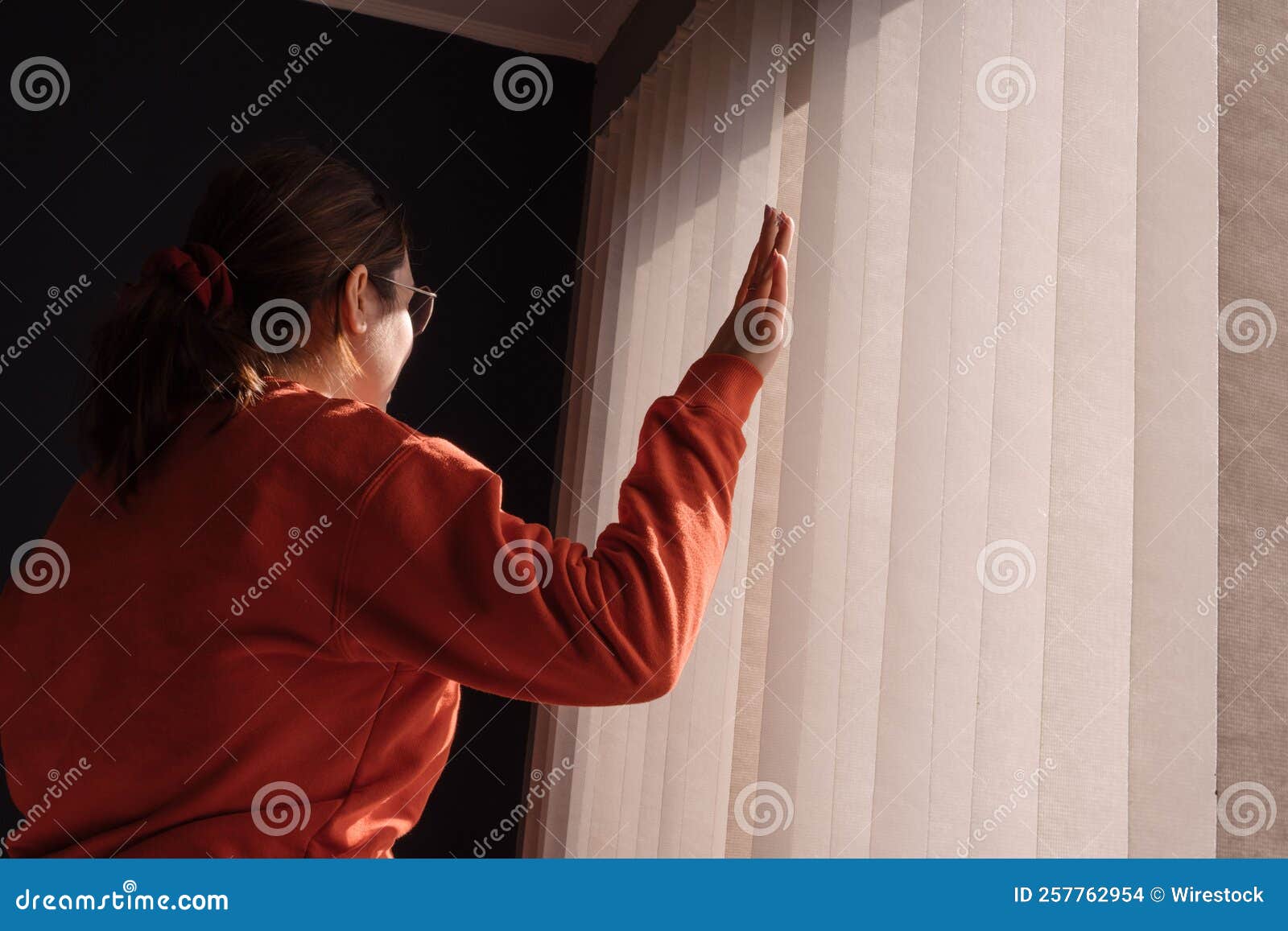 Back View of a Female Looking Out of the Window Blinds Stock Photo ...