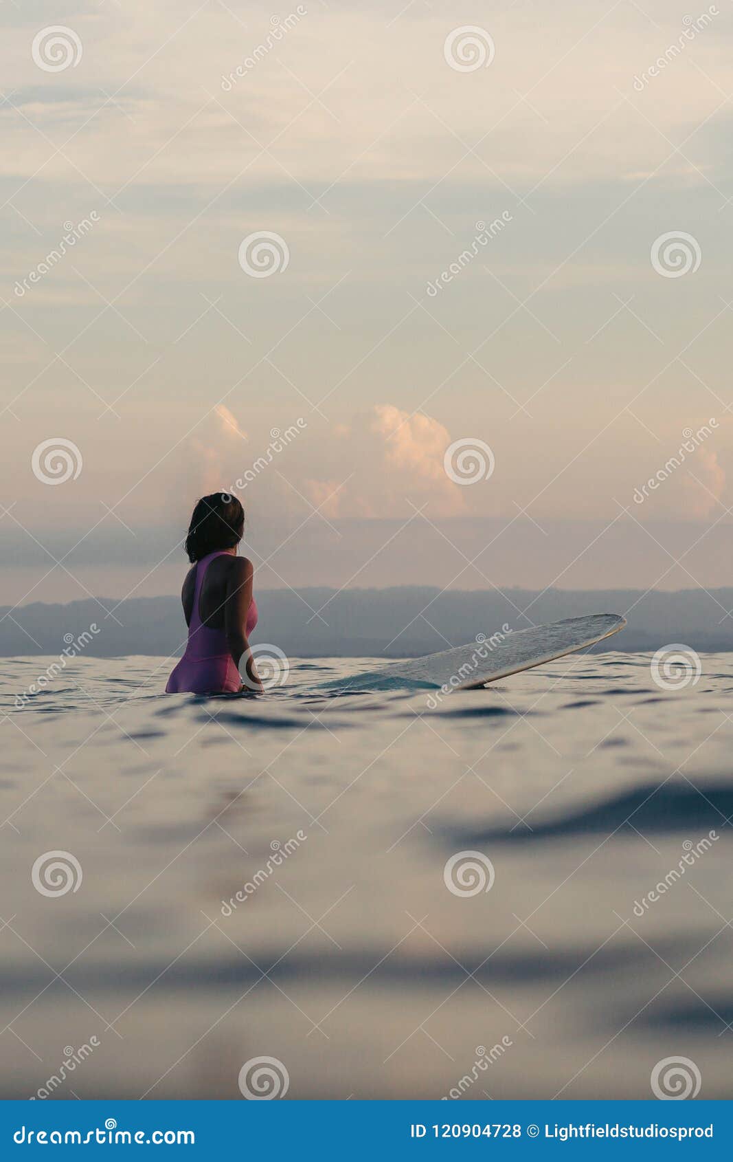 Back View of Female Surfer Sitting on Surfboard in Water Stock Photo ...