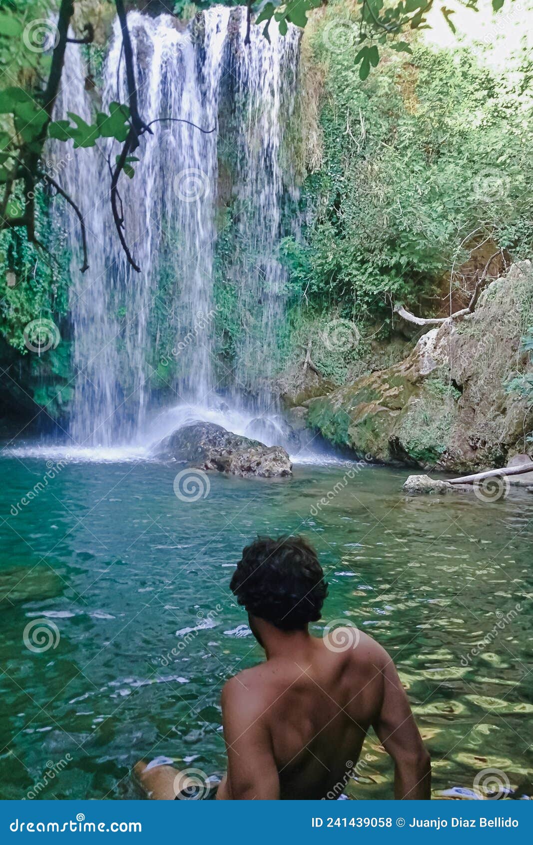 Back View of Man Looking at a Waterfall in the Mountains. Stock Photo ...