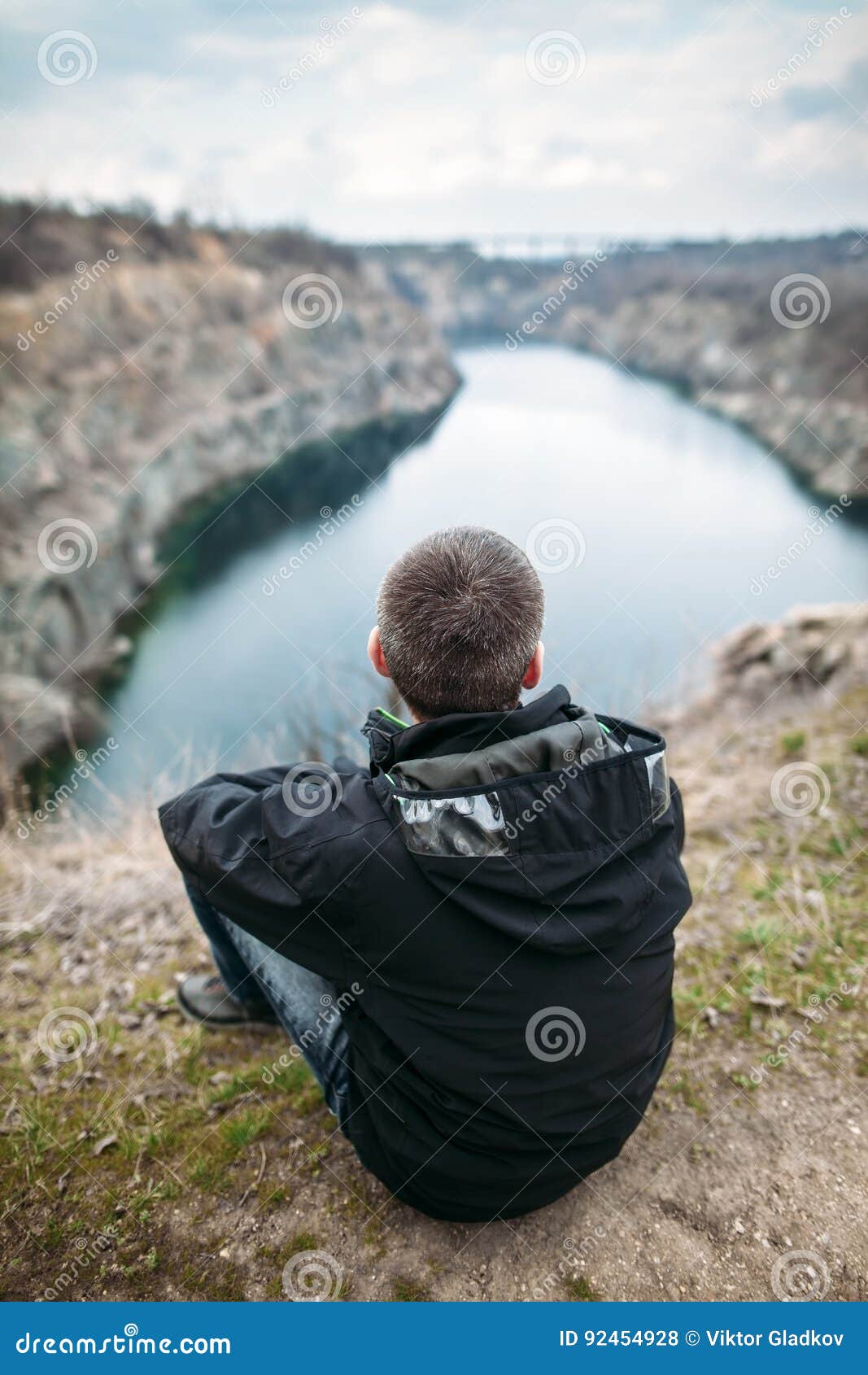 Back View of Man Relax on Rocky Cliff and Enjoying Nature Stock Photo ...