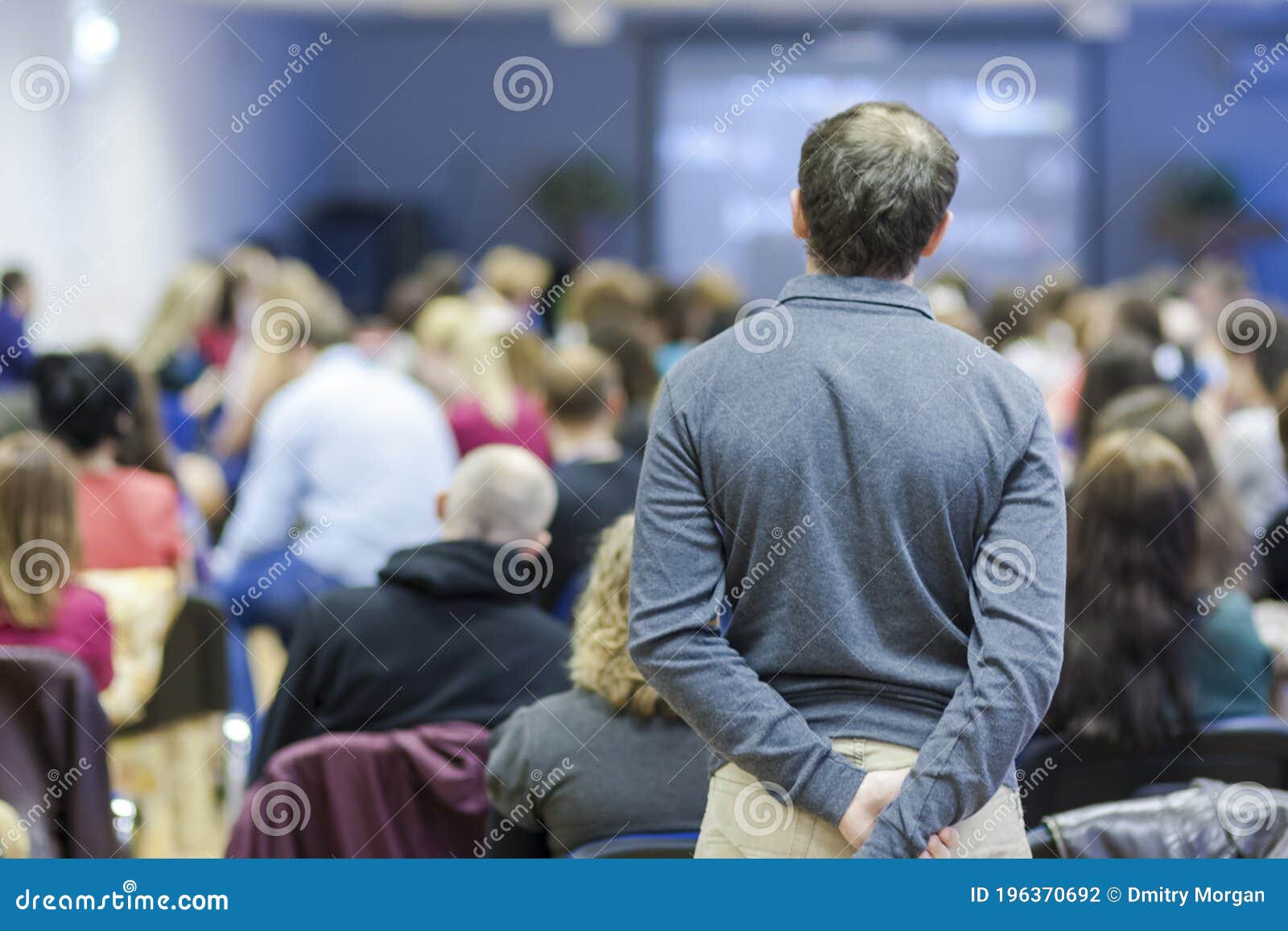 Back View of a Man Standing Behind a Large Group of People Attending ...