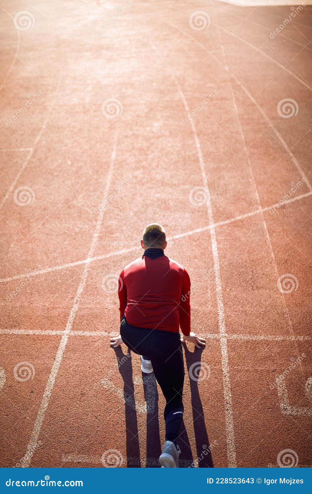 Back View of Man in Starting Position for Running on Race Track in ...