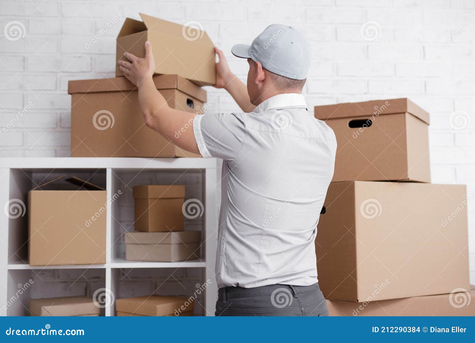 Back View of Man in Uniform Taking a Box from Shelf in Storehouse Stock ...