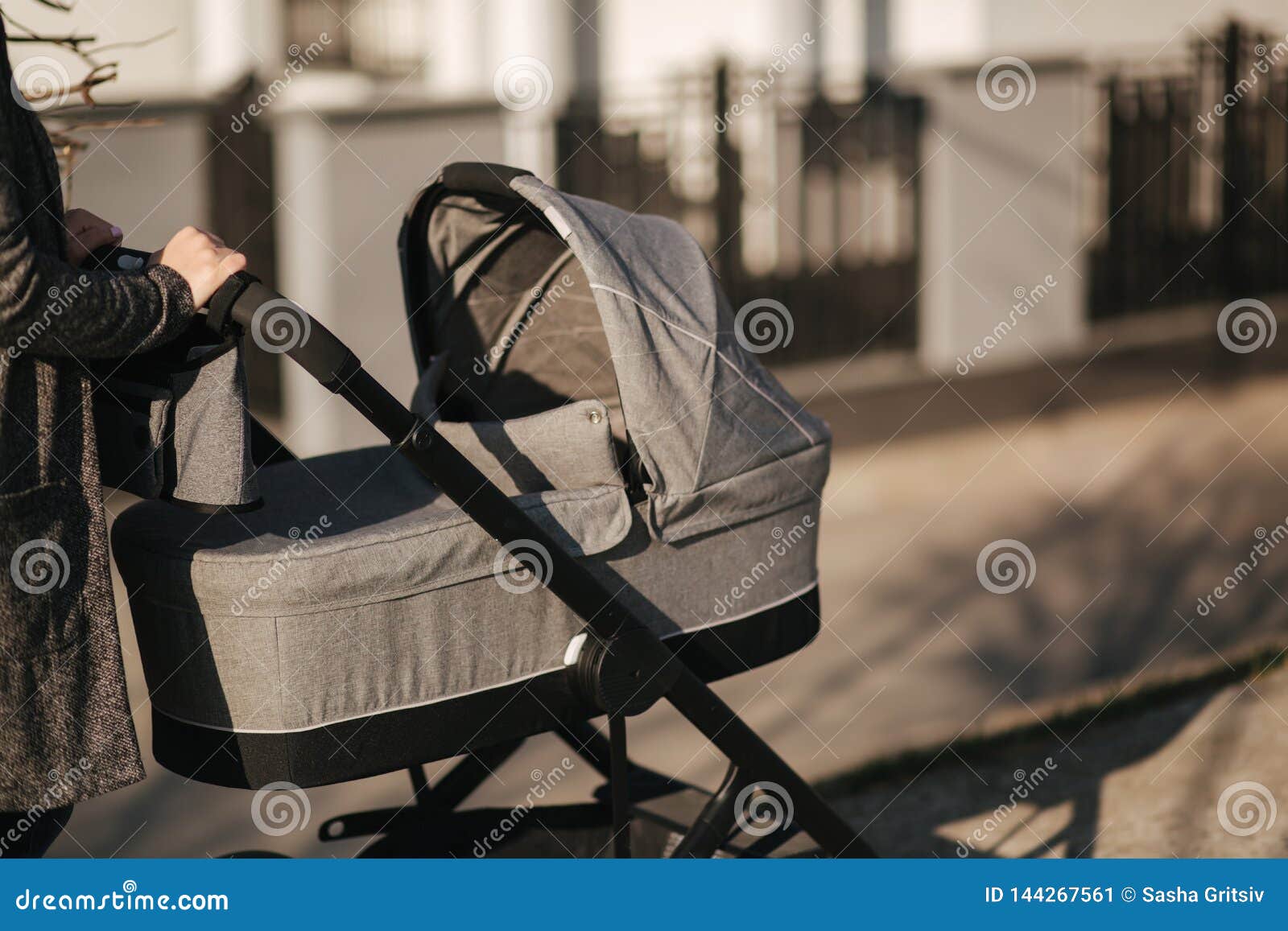 Back View of Mother Walking with Her Baby in Stroller. Grey Stroller ...