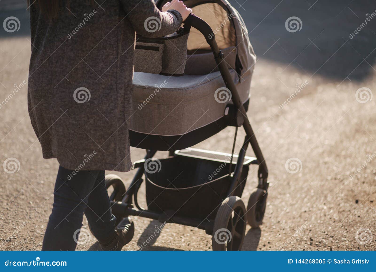 Back View of Mother Walking with Her Baby in Stroller. Grey Stroller ...