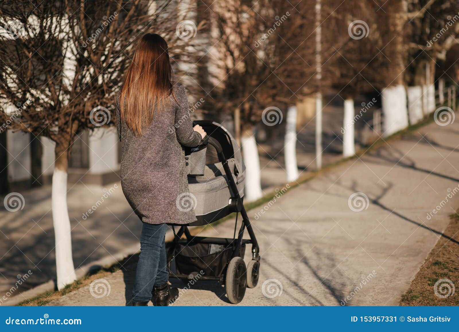 Back View of Mother Walking with Her Baby in Stroller. Grey Stroller ...