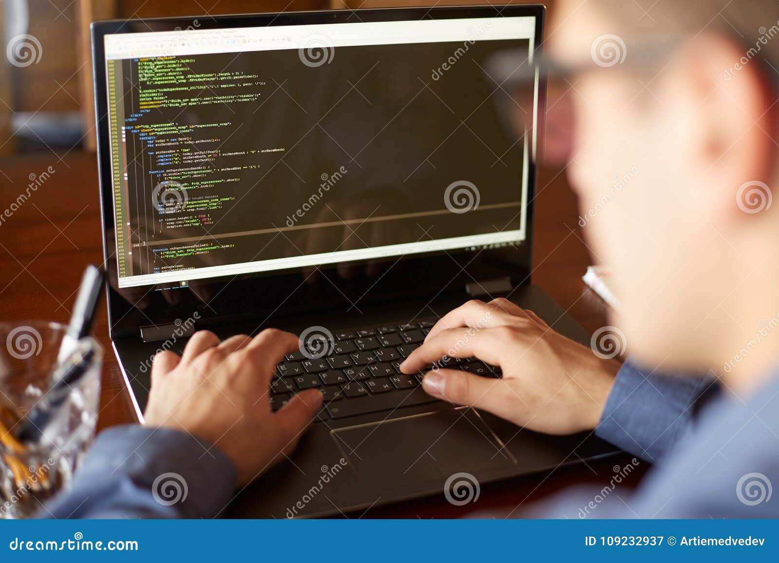 Back View Over the Shoulder Shot of Developer Programmer with Laptop ... Back View Over the Shoulder Shot of Developer Programmer with Laptop ...