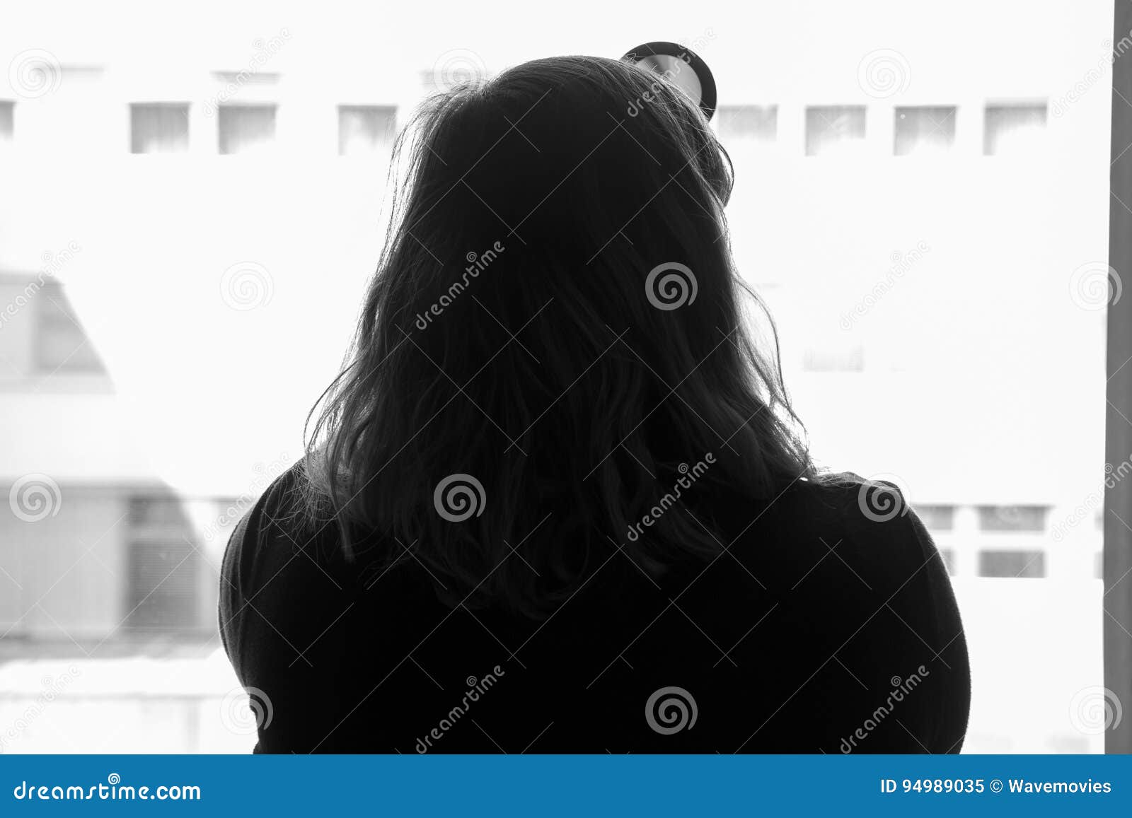 Back View of Silhouette of a Woman Putting on Makeup in Front of Stock ...