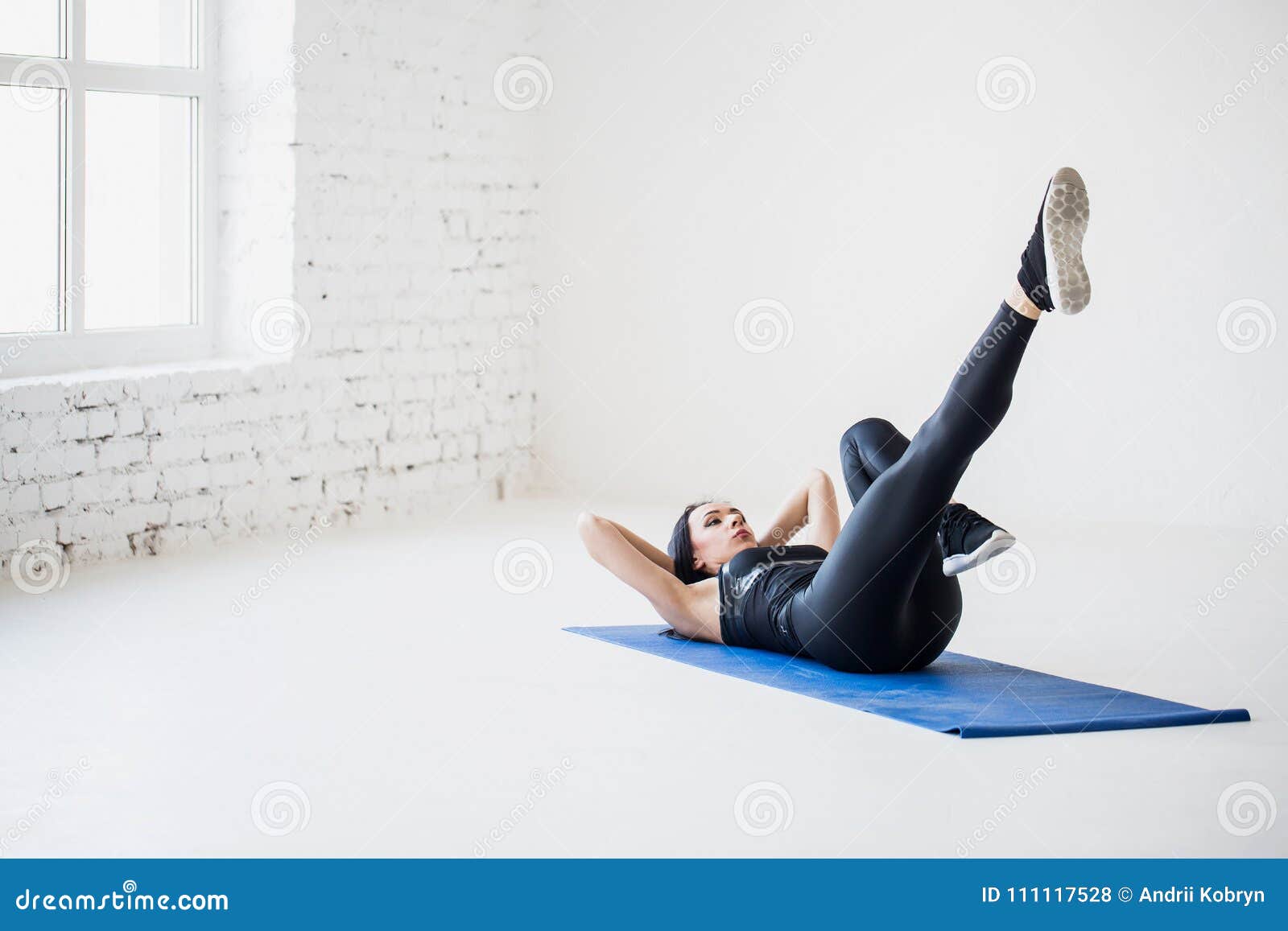 Back View of the Sports Lade Warming Up by Lying on the Exercise Mat ...
