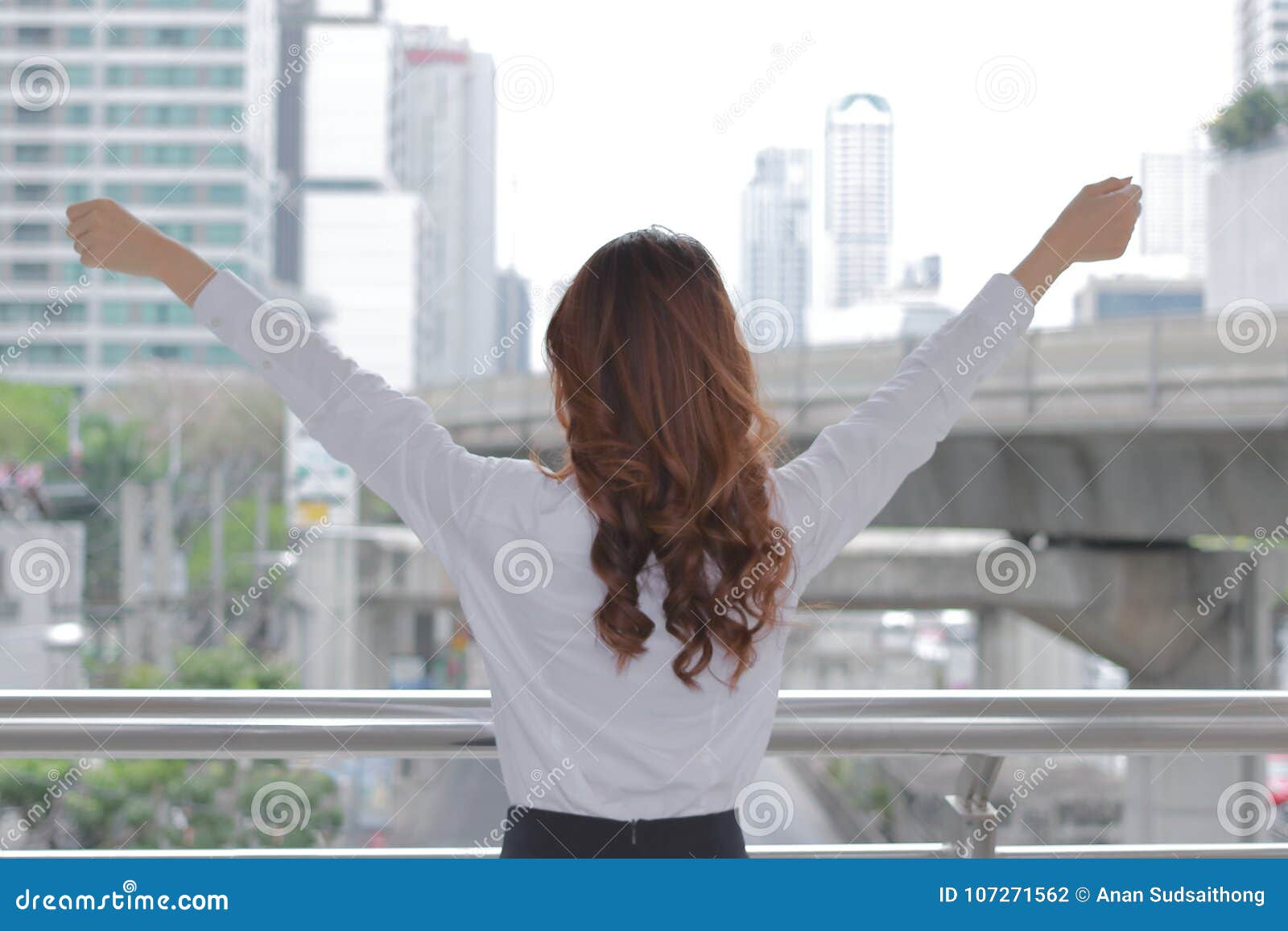 Back View of Successful Young Aian Business Woman Raising Her Hands at ... Back View of Successful Young Aian Business Woman Raising Her Hands at ...