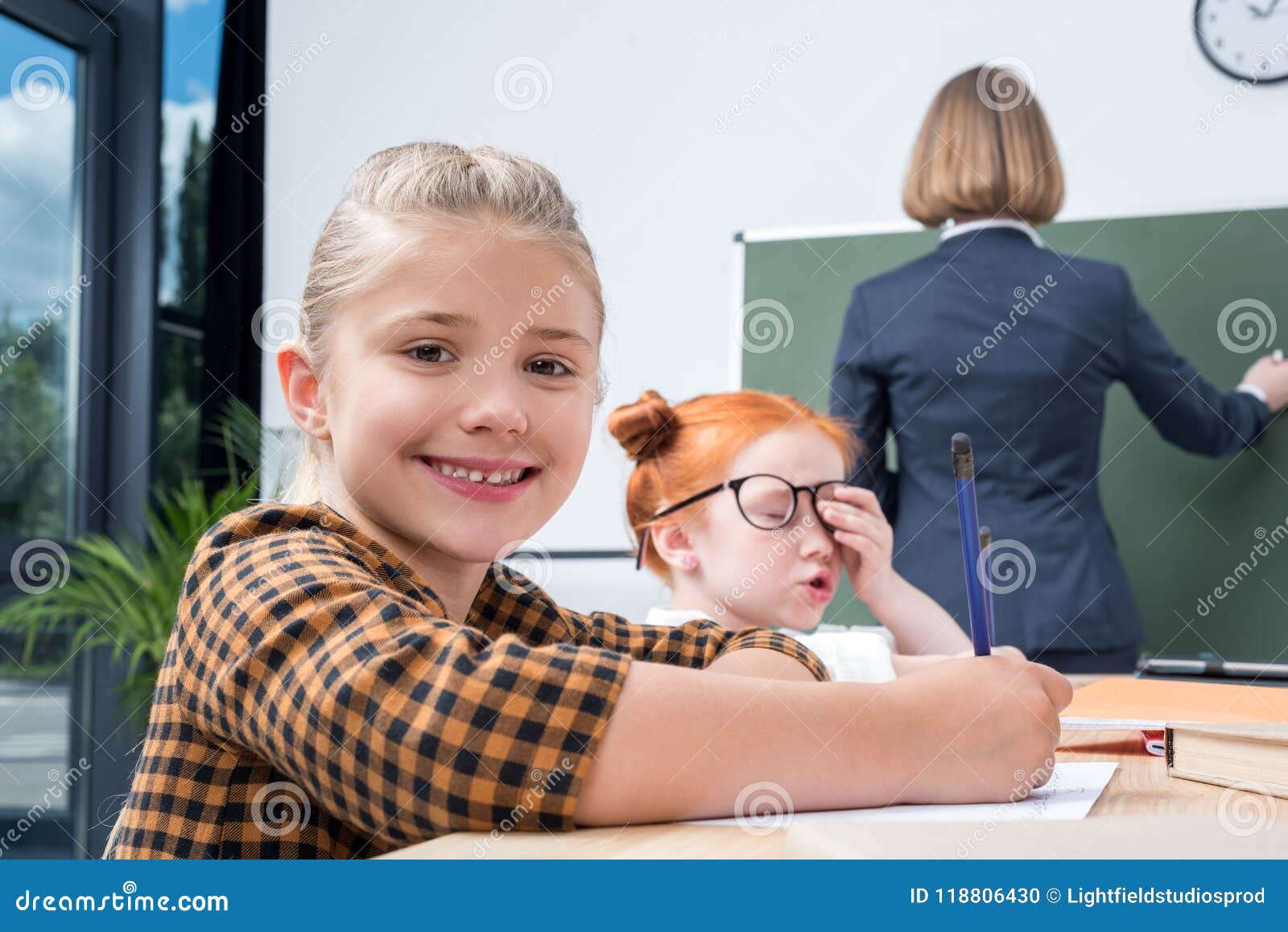 Back View of Teacher Writing on Chalkboard while Students Studying ... Back View of Teacher Writing on Chalkboard while Students Studying ...
