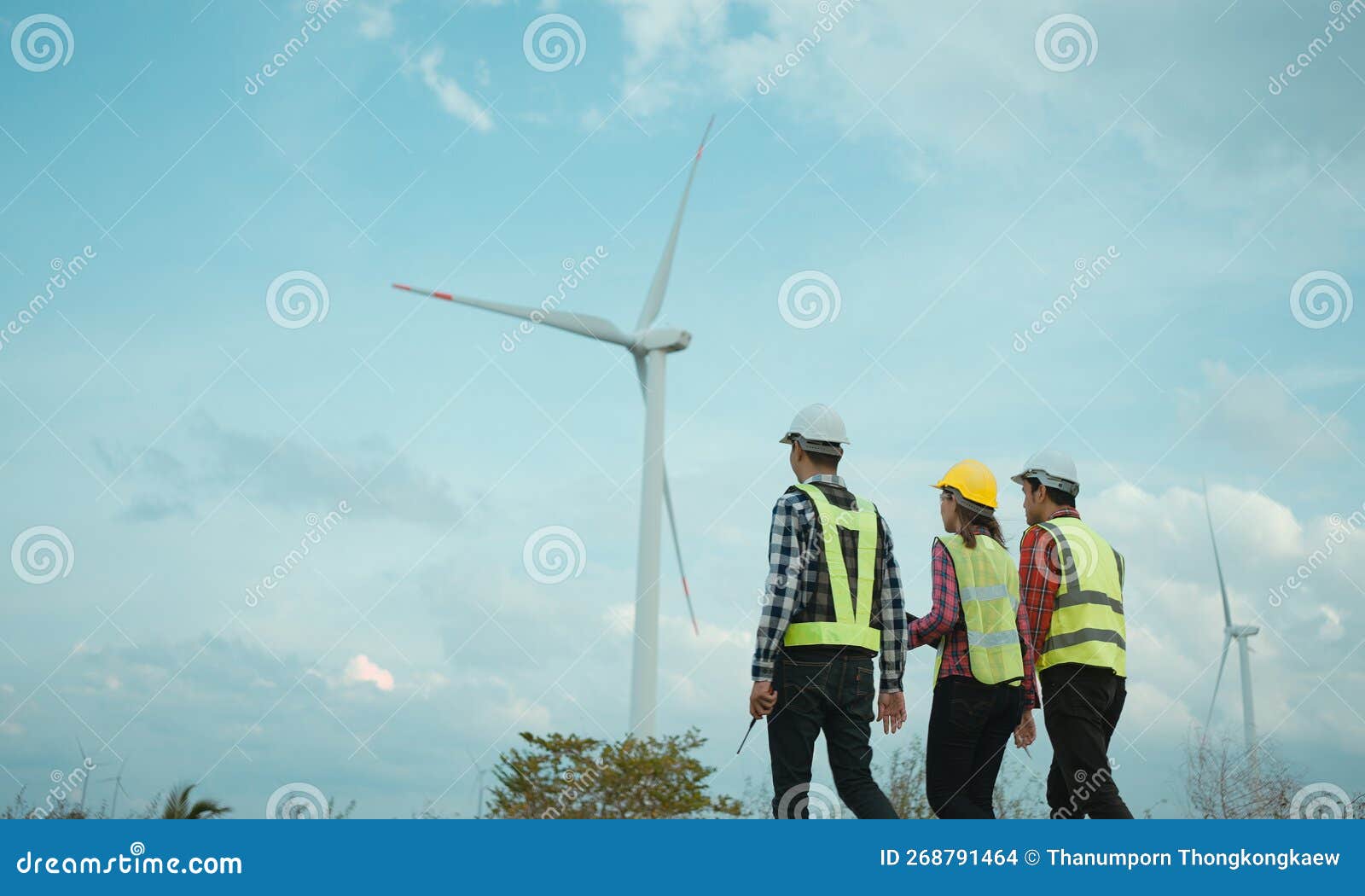 Back View of Three Engineers Discussing and Progress Check Wind Turbine ...