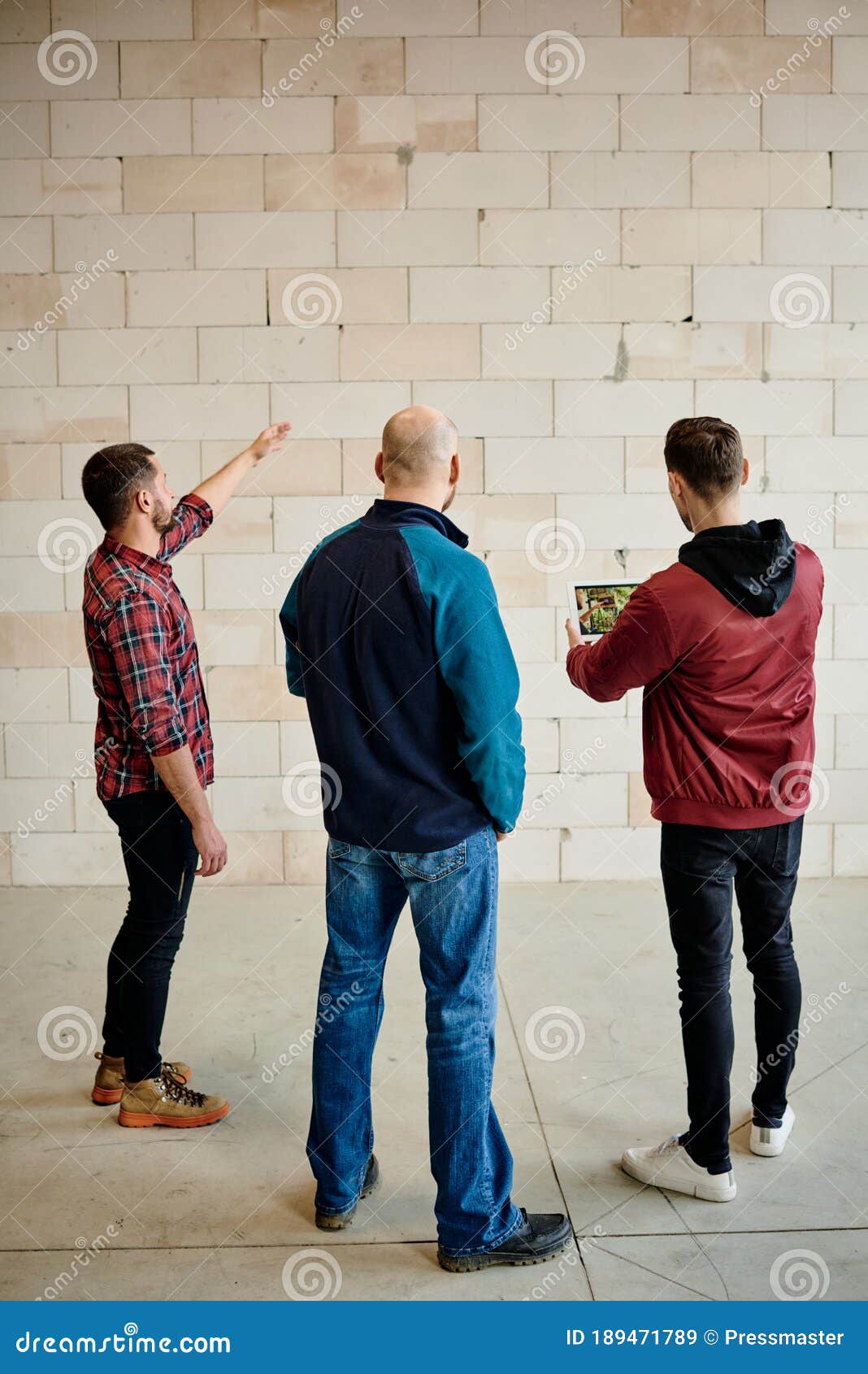 Back View of Three Young Builders or Architects Discussing Quality of ...