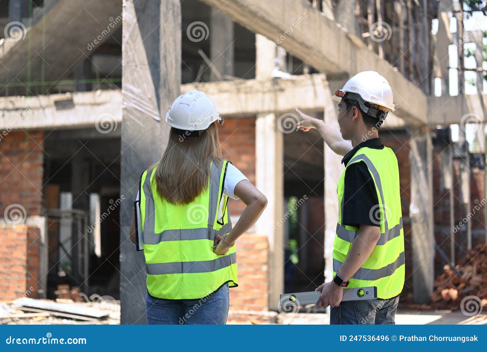 Back View of Two Engineer Discussing New Plan at Construction Site ...