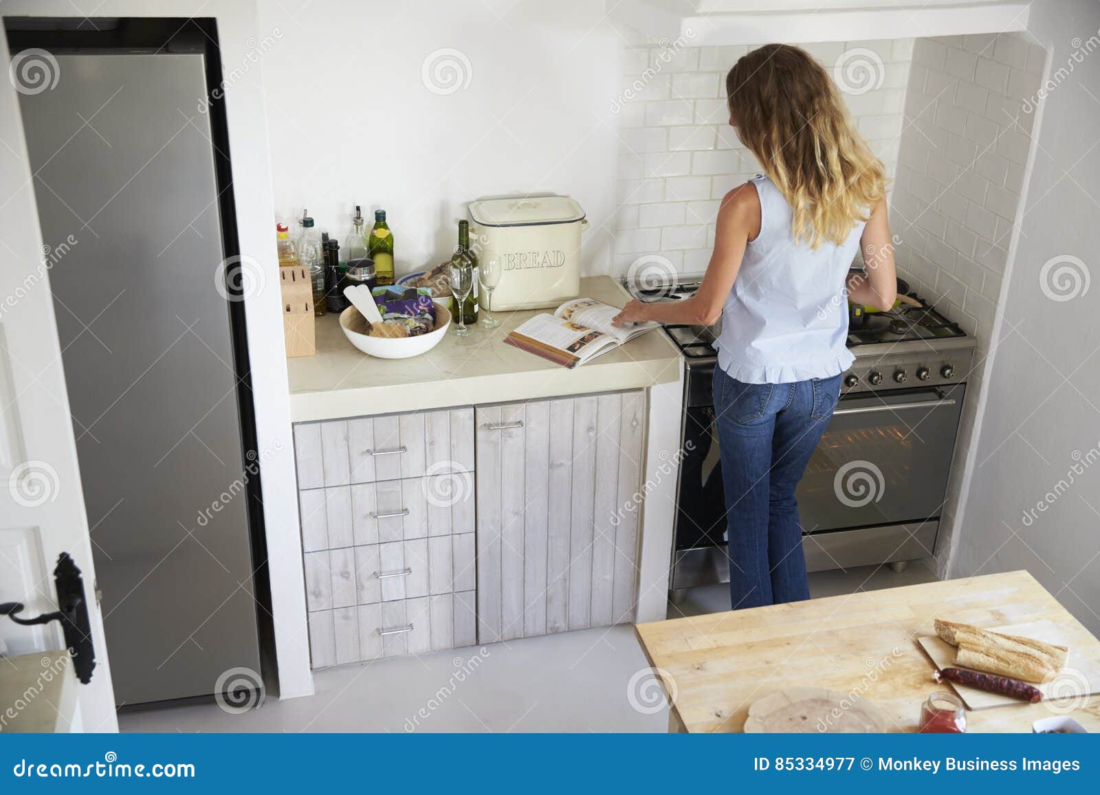 Back View of Woman Cooking in Kitchen, Reading Recipe Book Stock Image ...