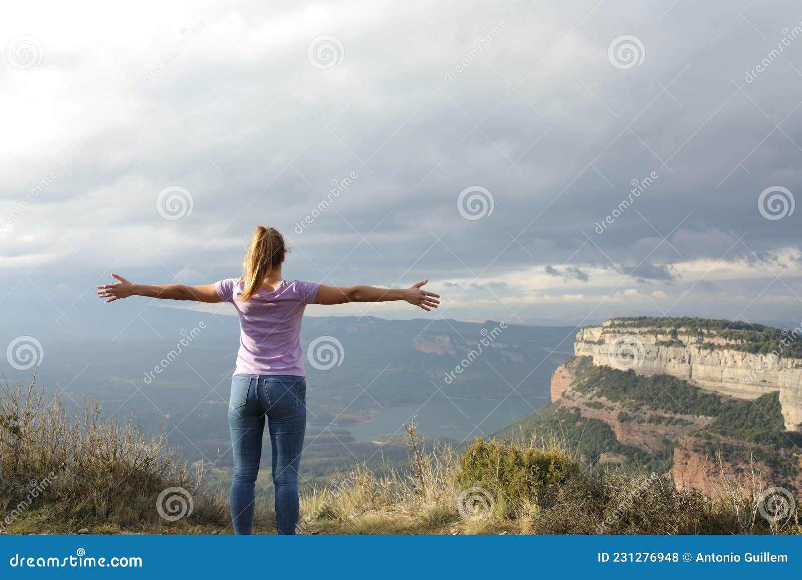 Back View of a Woman Outstretching Arms in a Cliff Stock Photo - Image ...