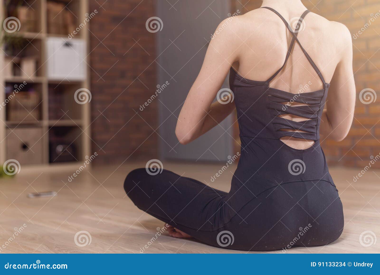 Back View Of Woman Sitting In Yoga Lotus Pose Relaxing And Meditating