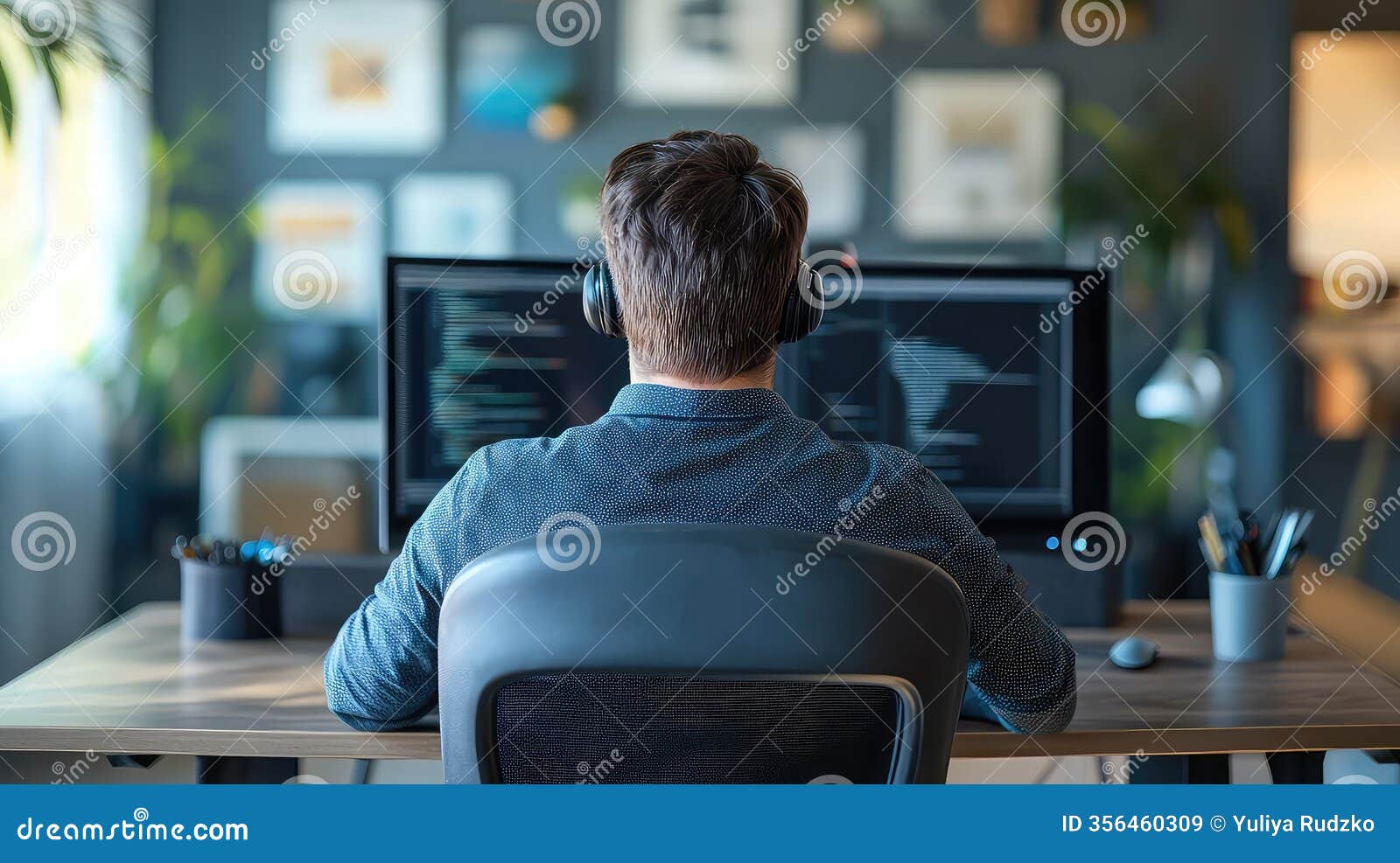 Back View of it Worker Sitting at Desk and Programming on Computer, Focused and Engaged in ...