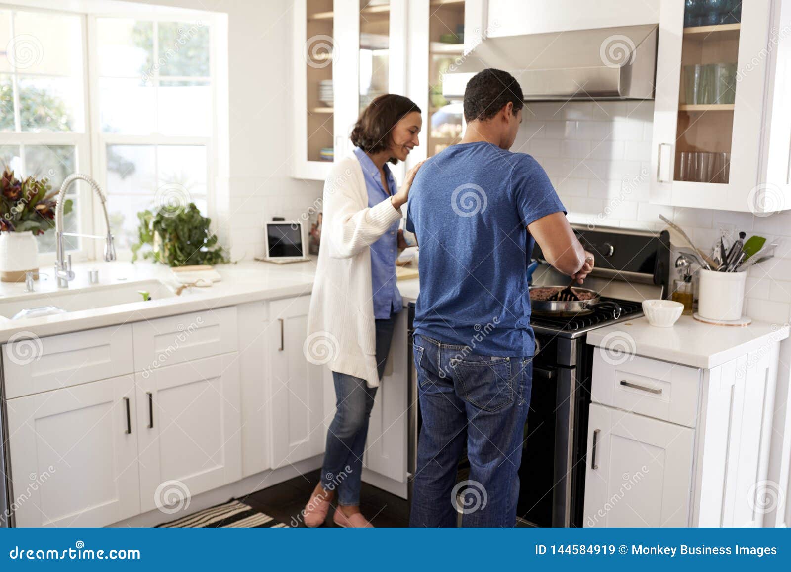 Back View of Young Couple Standing in the Kitchen Preparing Food ...
